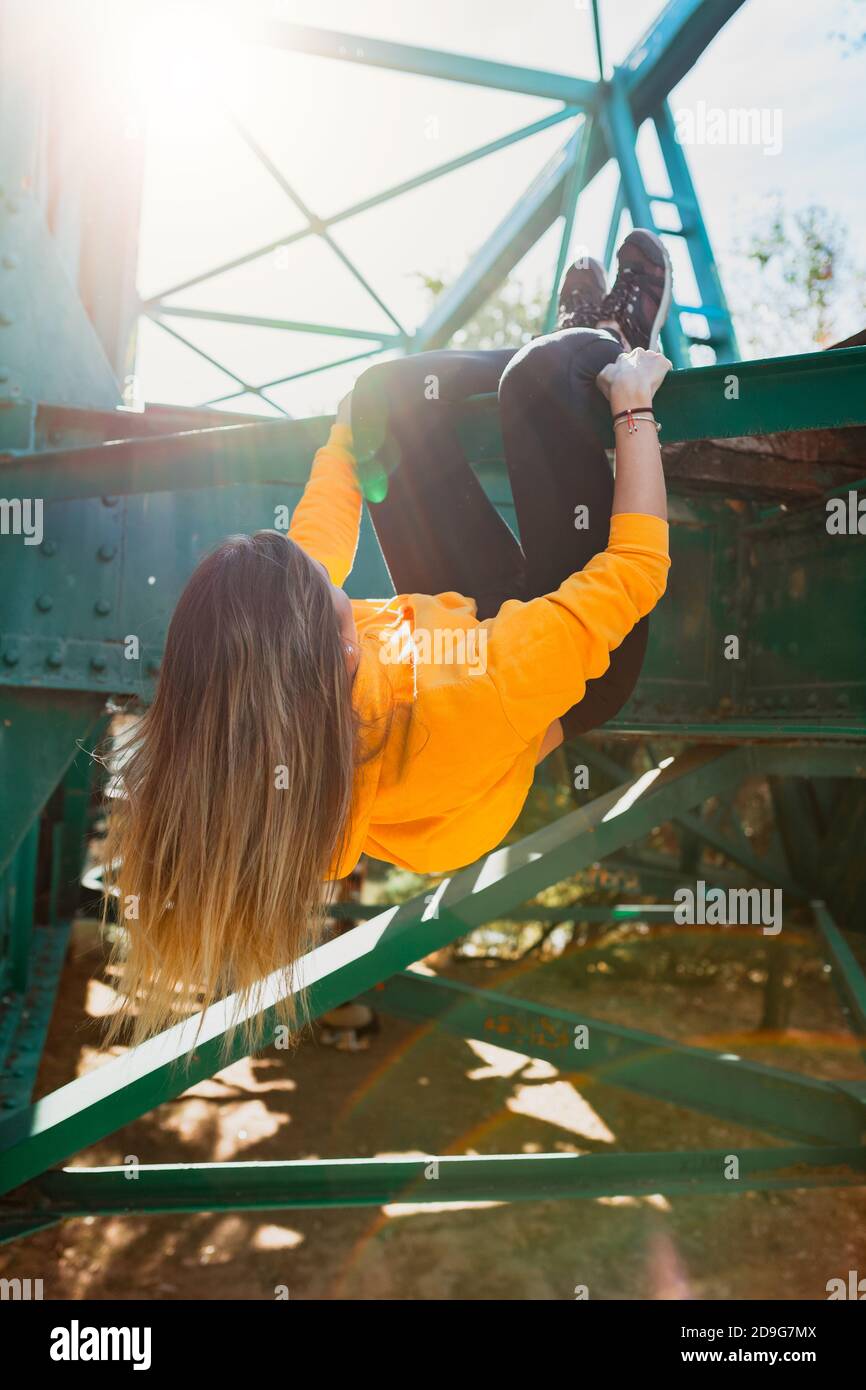 Woman hanging like a monkey from iron beams. Freedom concept Stock ...