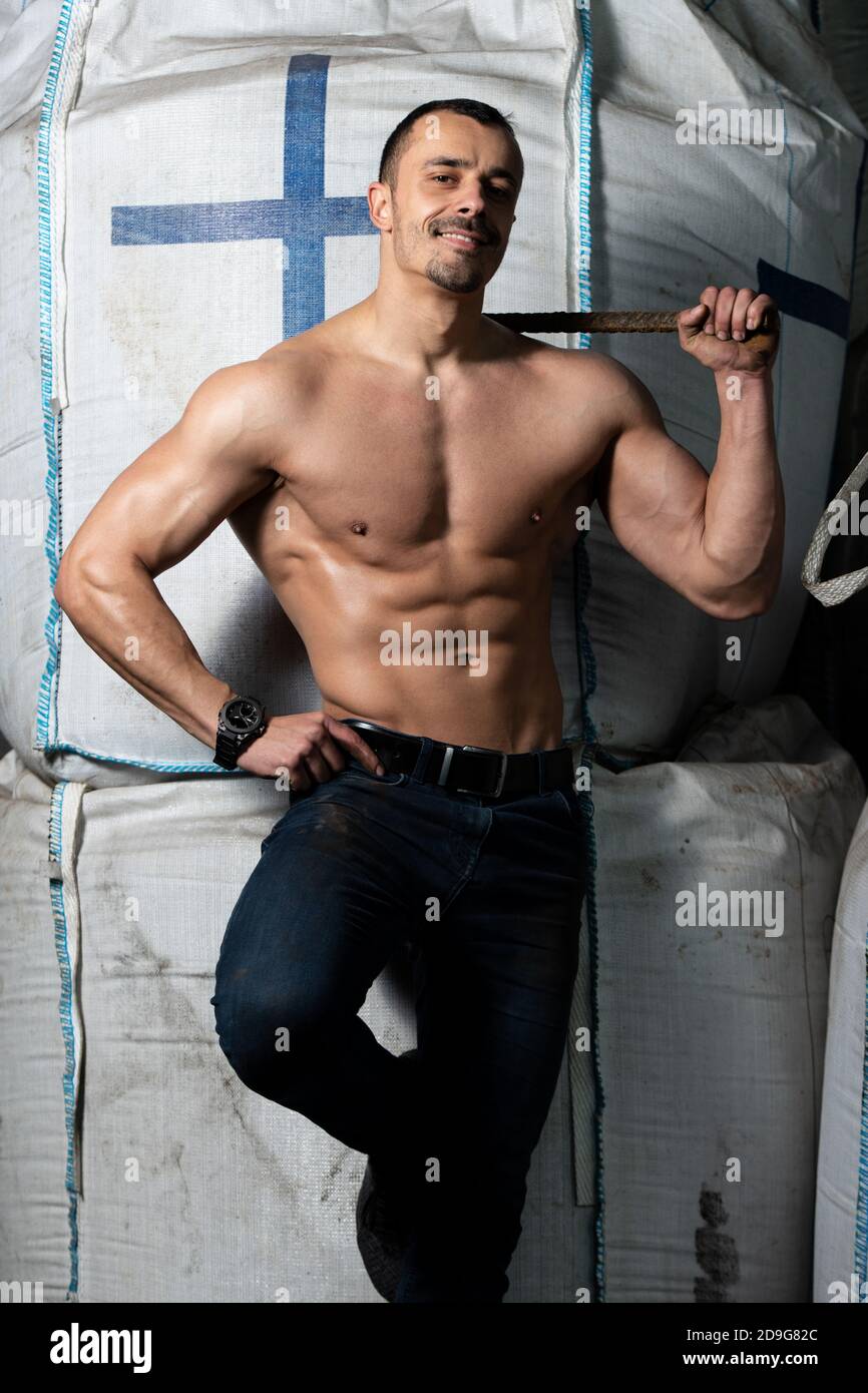Portrait of a Young Physically Fit Man Standing In Warehouse With Big ...