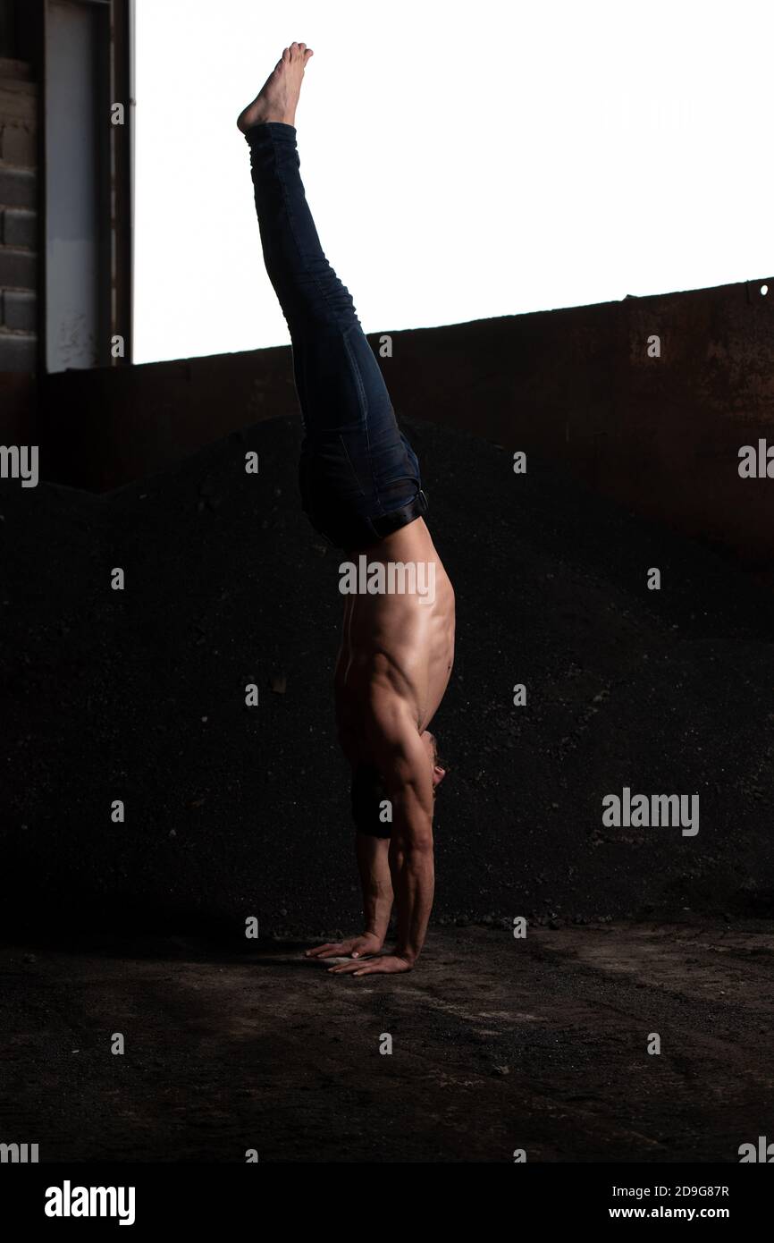 Handsome Man Keeping Balance on Hands in Warehouse - Muscular Athletic ...