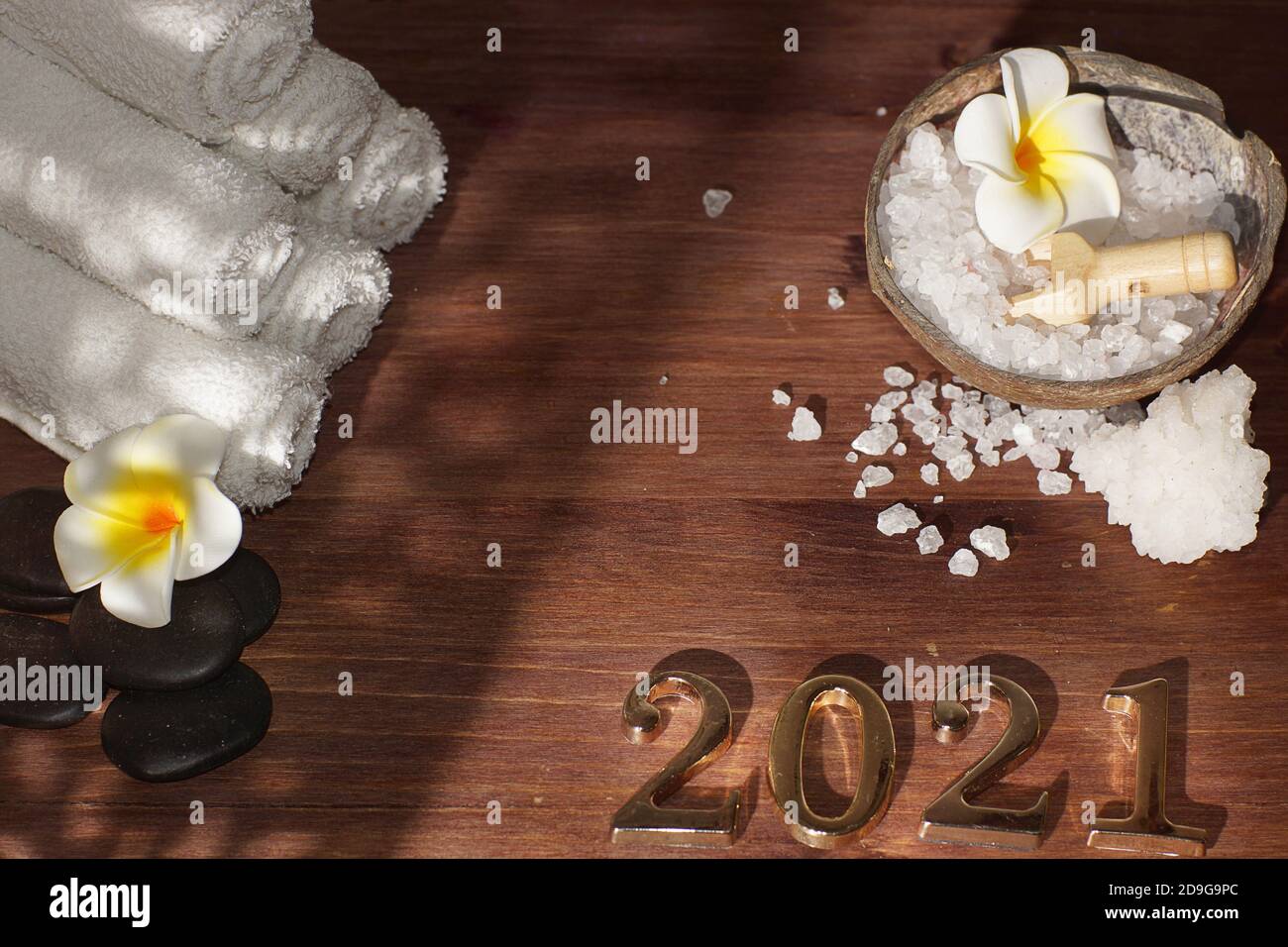 The numbers 2021 are on a wooden table next to a set prepared for a spa ...
