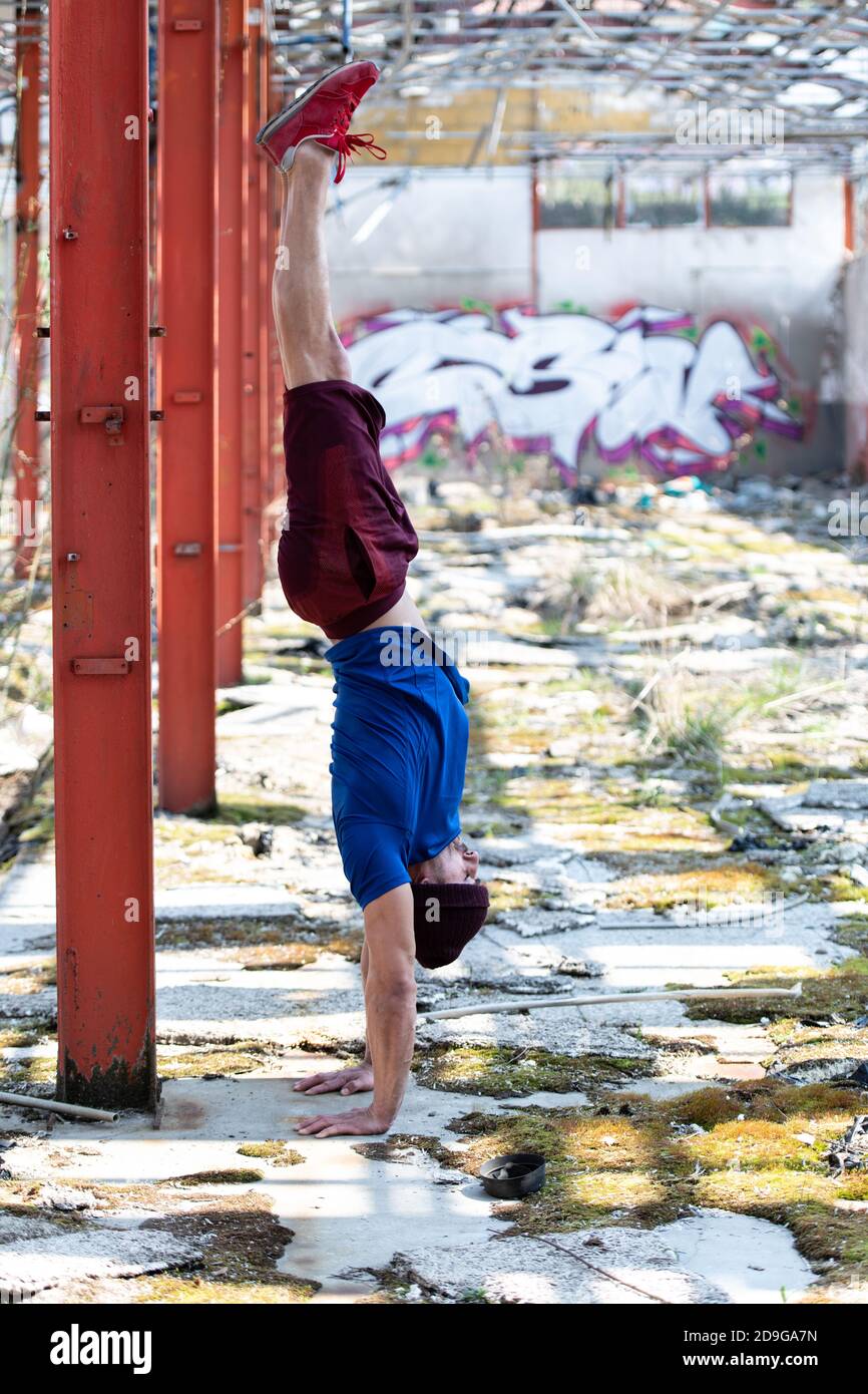 Young Man Standing on Hands Strong and Keeping Balance in Warehouse ...