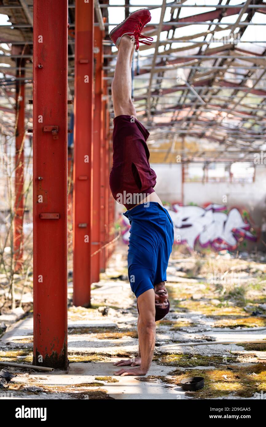 Handsome Man Standing on Hands Strong and Keeping Balance in Warehouse ...
