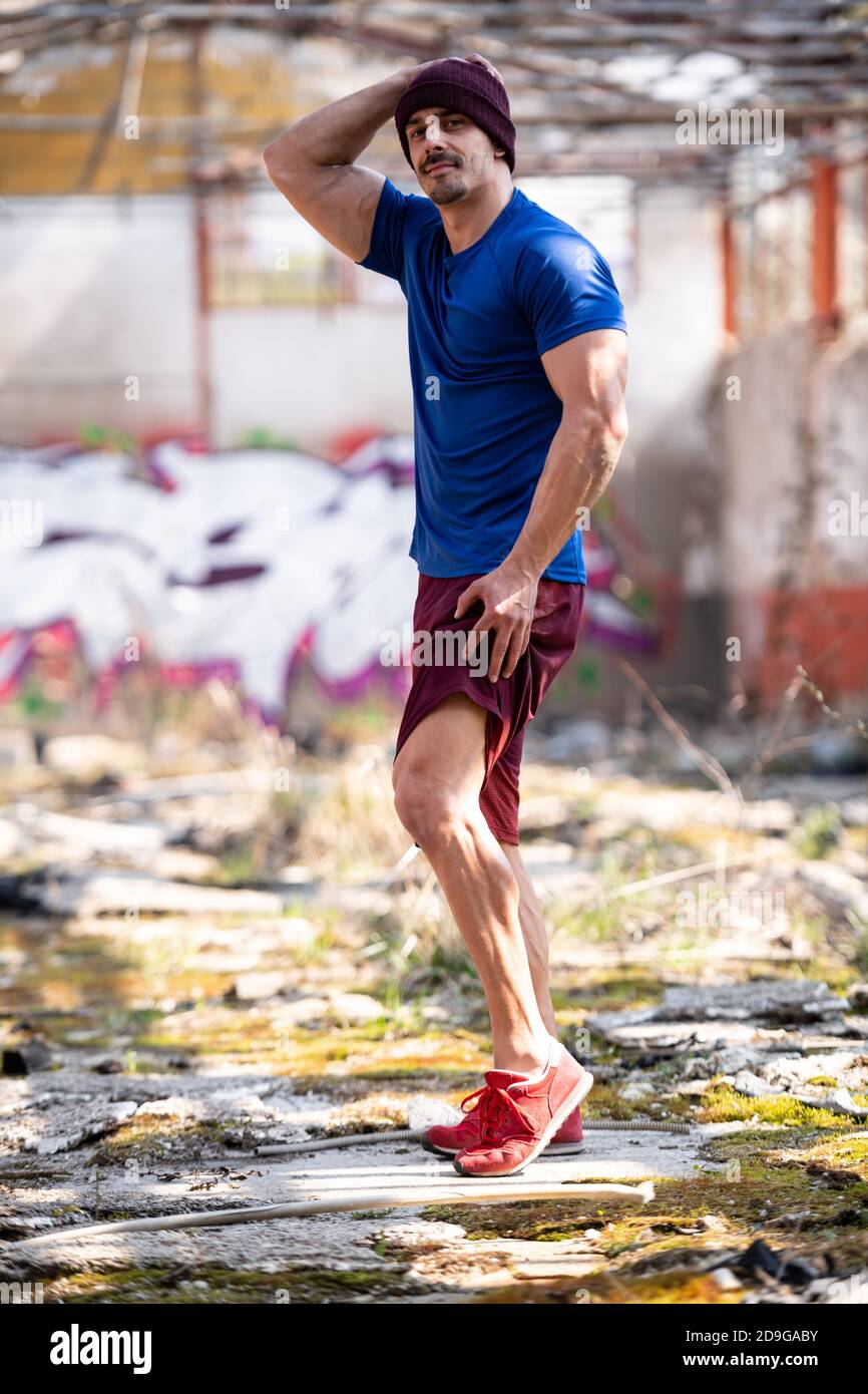Handsome Man Standing Strong in Warehouse and Flexing Muscles ...