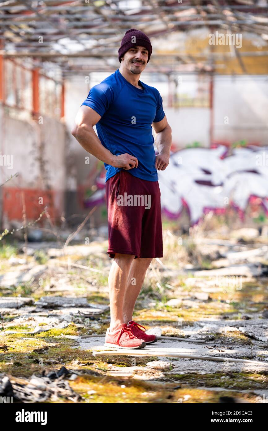 Handsome Man Standing Strong in Warehouse and Flexing Muscles ...