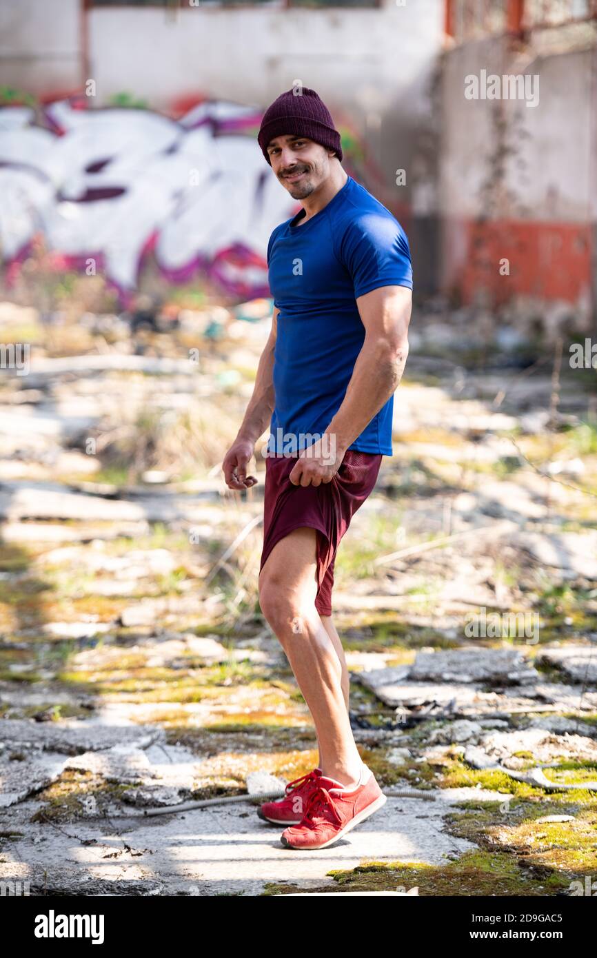 Young Man Standing Strong in Warehouse and Flexing Muscles - Muscular ...