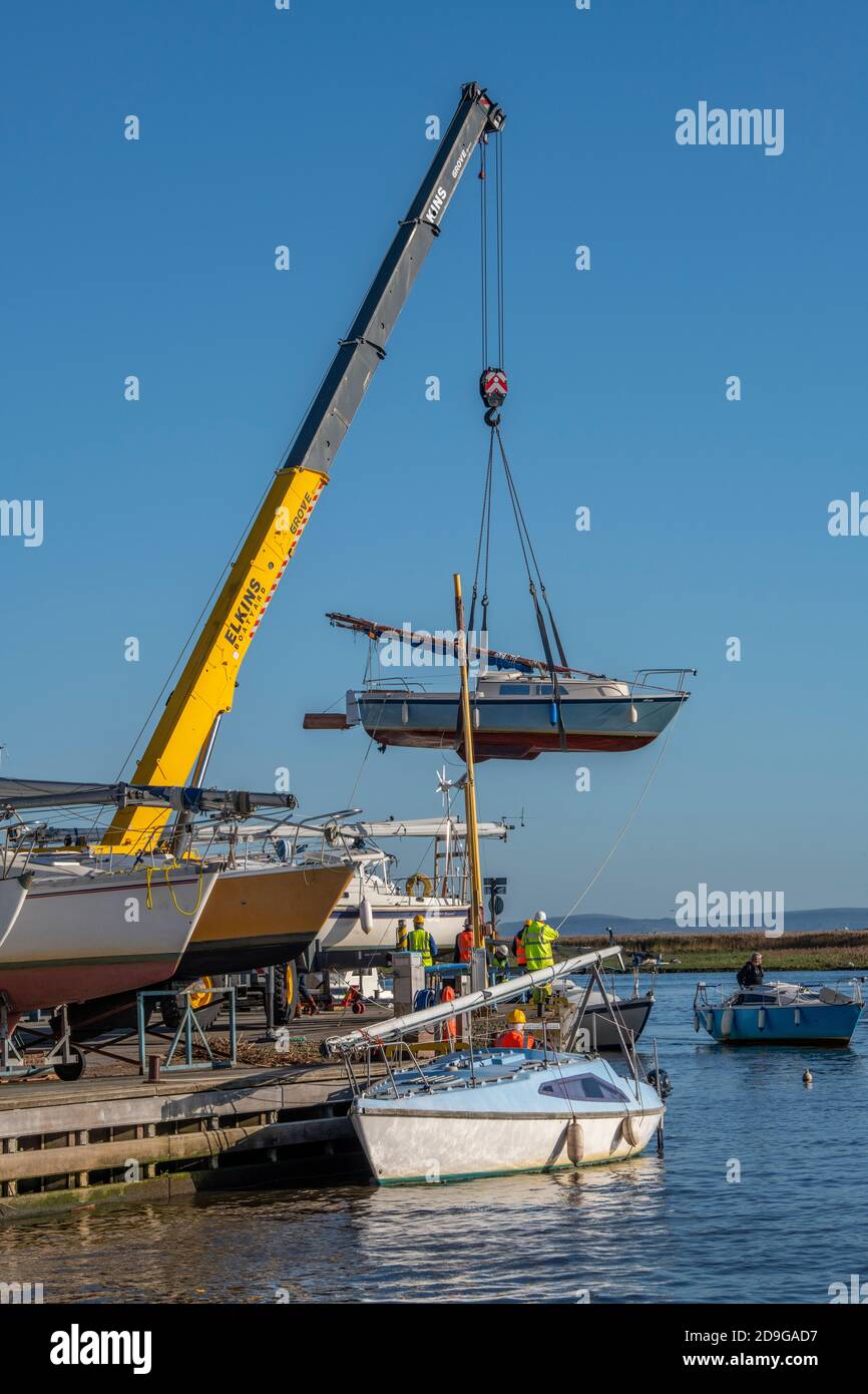 a yacht being lifted out of the water by a crane at a yachting marina ...