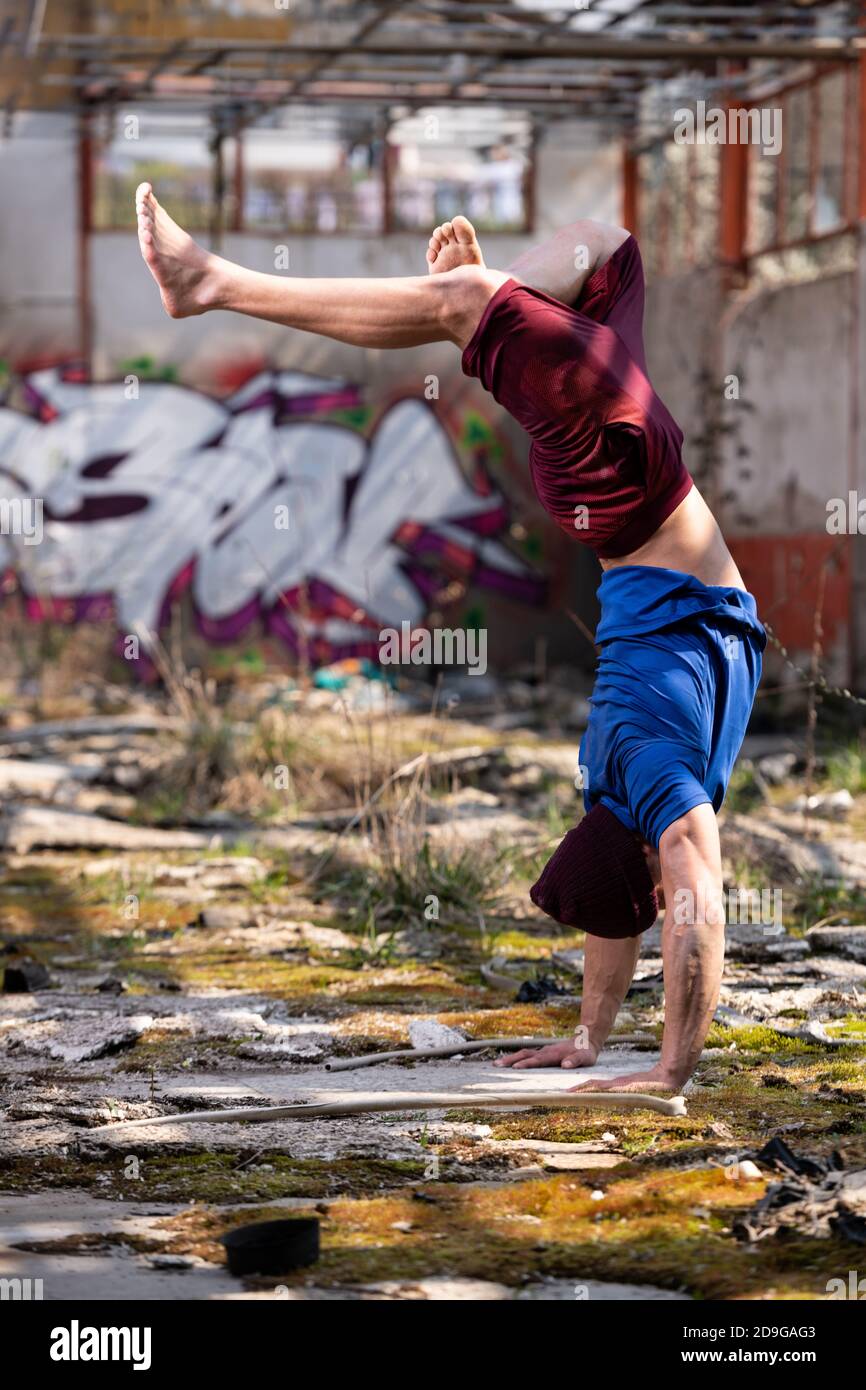 Young Man Standing on Hands Strong and Keeping Balance in Warehouse ...