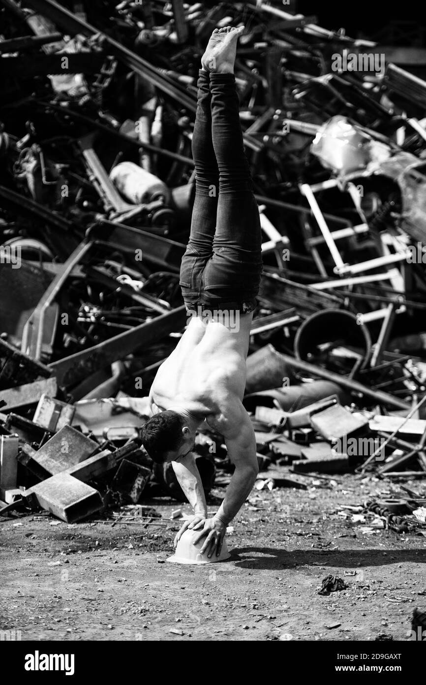 Handsome Man Keeping Balance on on Yellow Helmet With Hands in Old ...