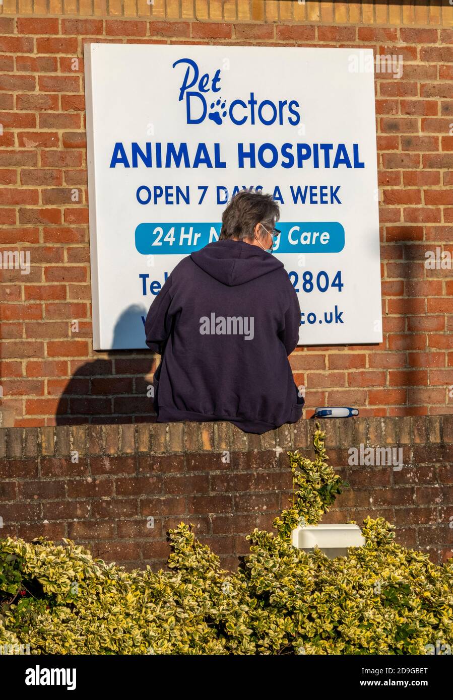 a woman waiting outside of a veterinary surgery or animal hospital to ...