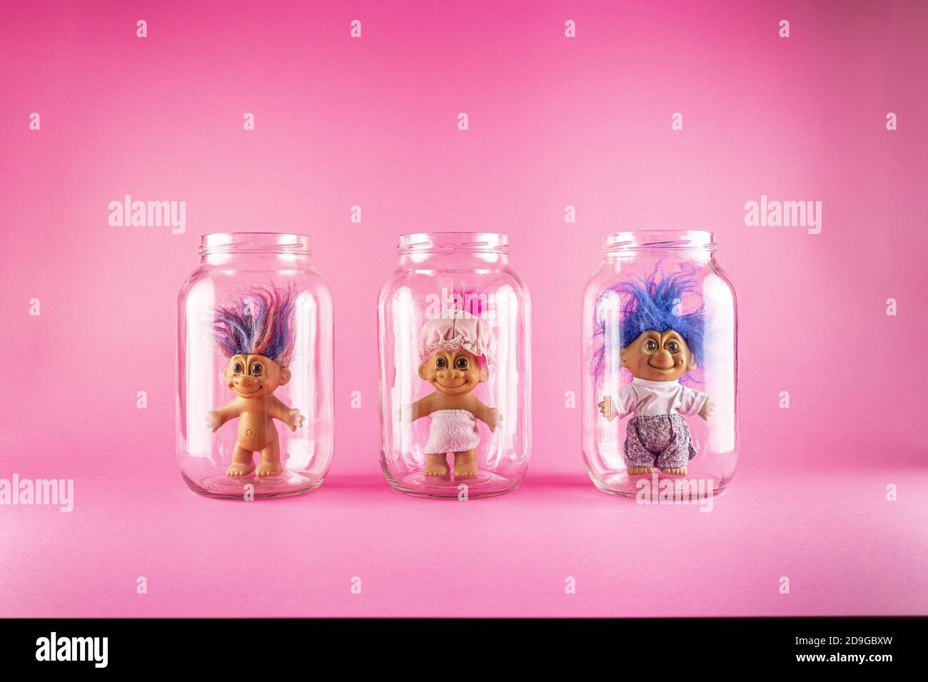 Funny toys in glass containers on a fink background Stock Photo - Alamy