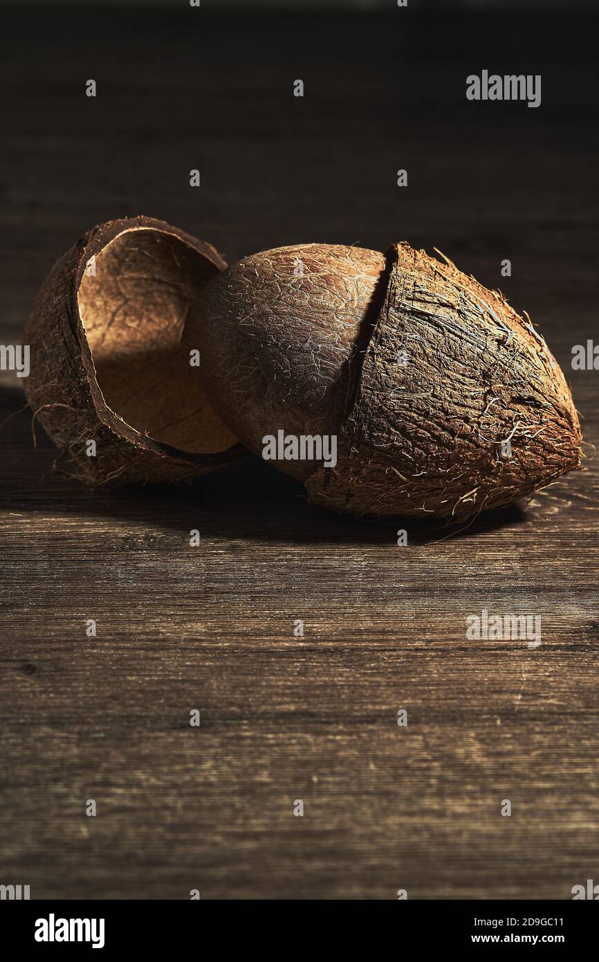 Vertical closeup shot of a broken coconut on the wooden table Stock ...