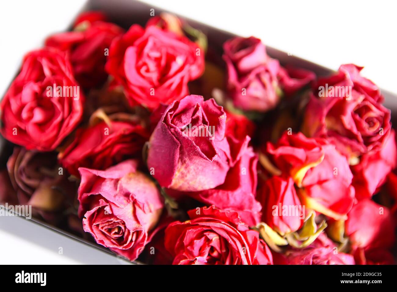 Red rose dried buds, flowers and petals in the opened cardboard box ...