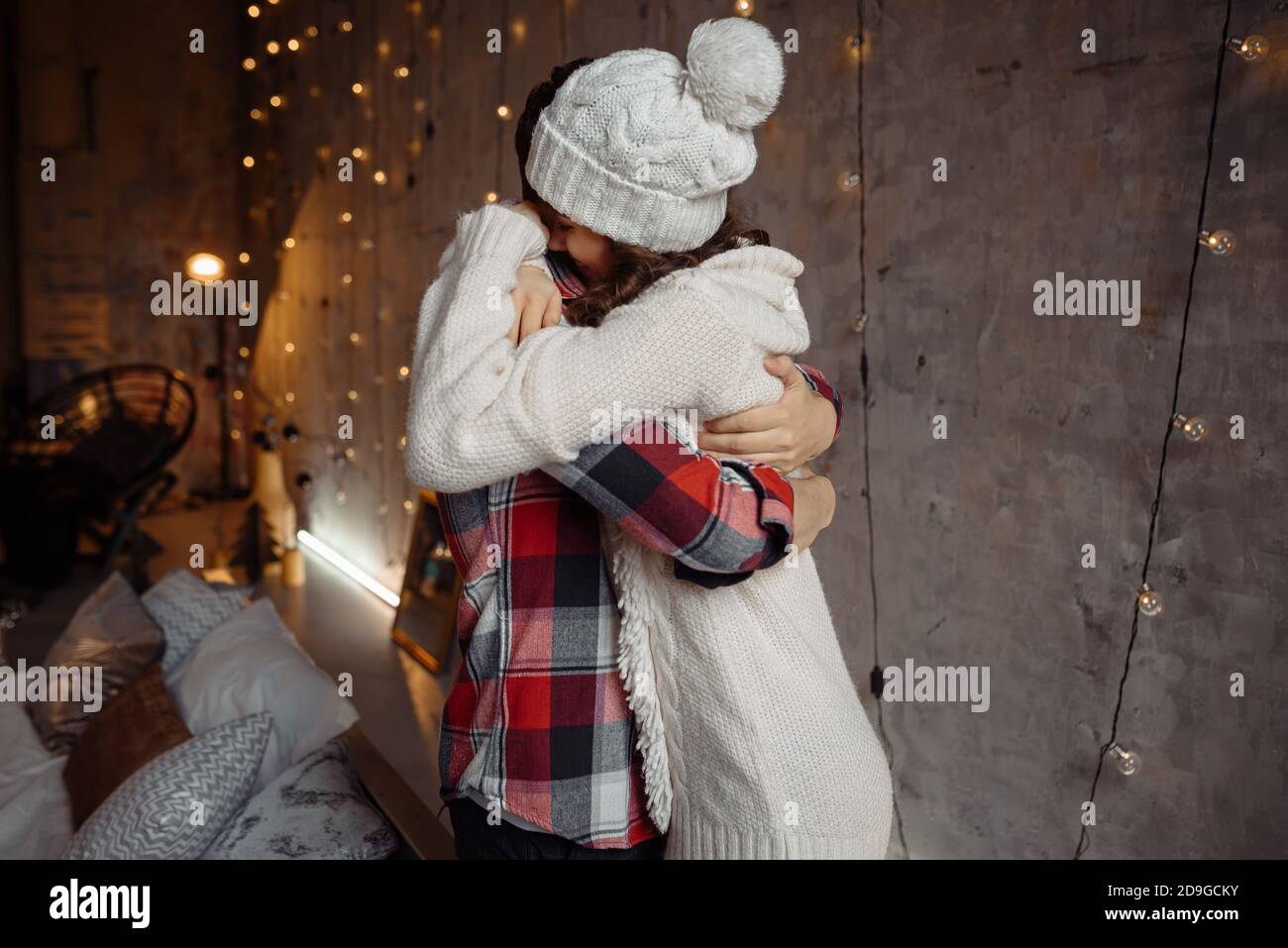 Stylish happy couple hugging each other and spending christmas eve ...
