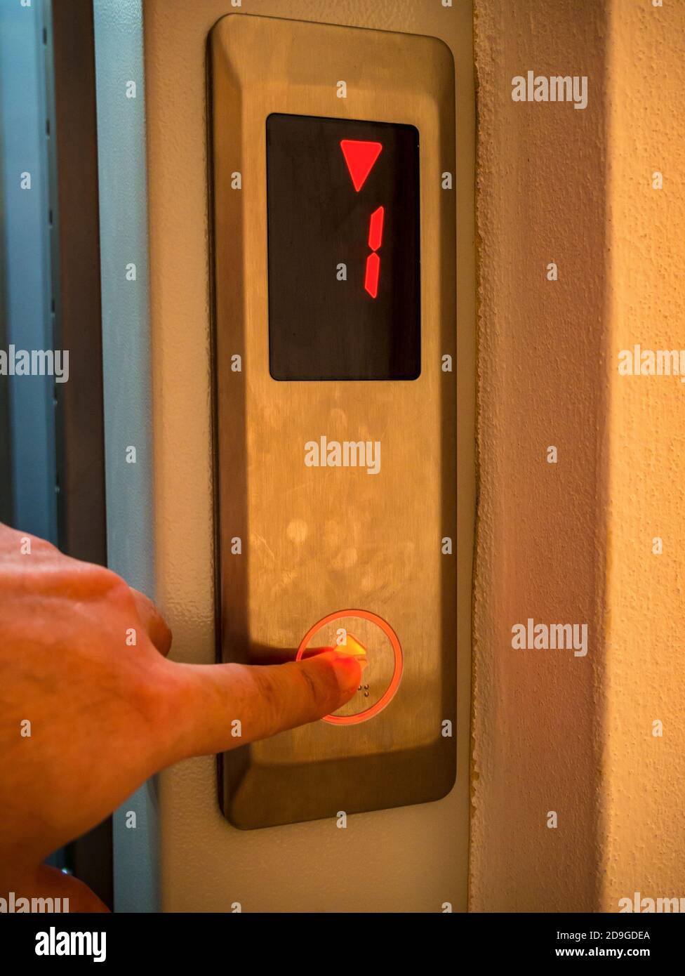 Hand presses the button of the elevator call Stock Photo - Alamy