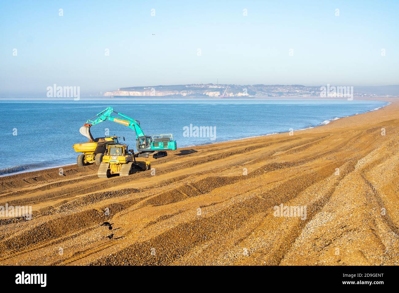 Replacing shingle washed along the coast by tides Stock Photo - Alamy