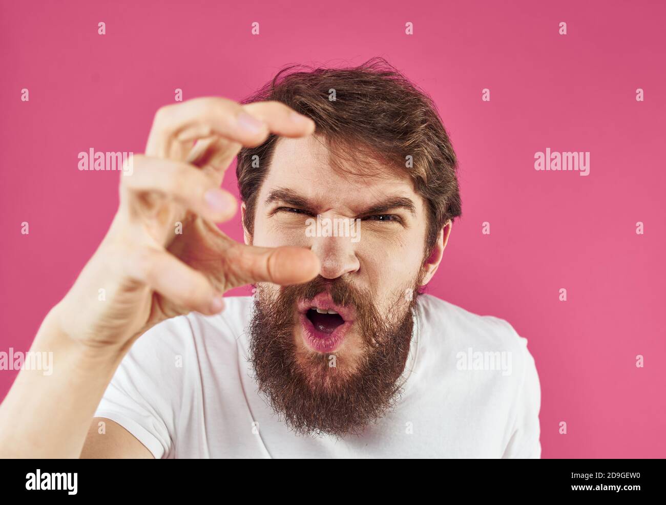Man on a pink background surprise irritability emotions and stress ...