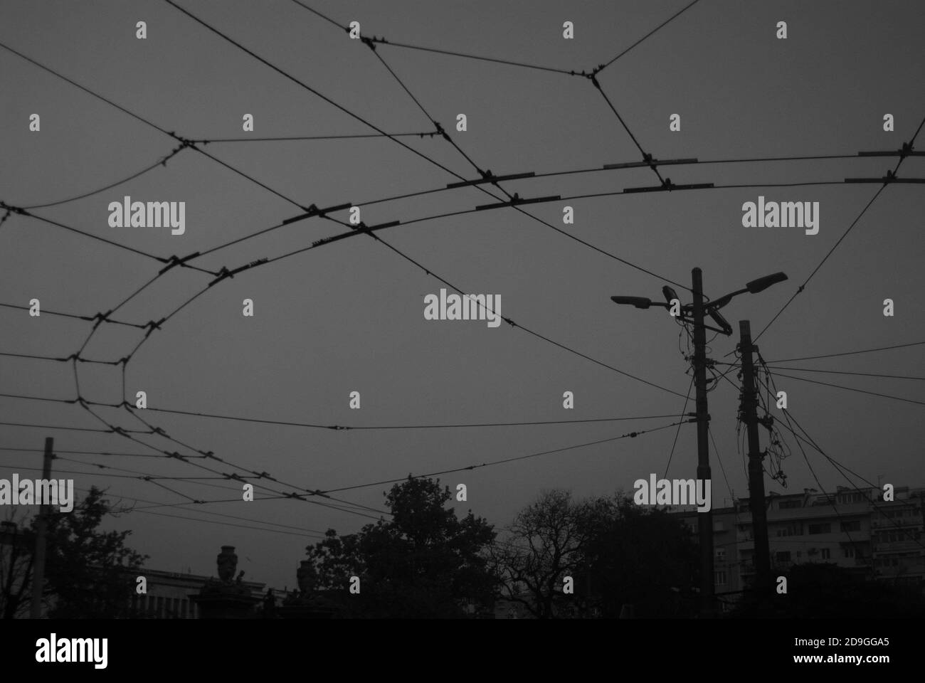 Grayscale shot of wires around the street light post forming a circle ...