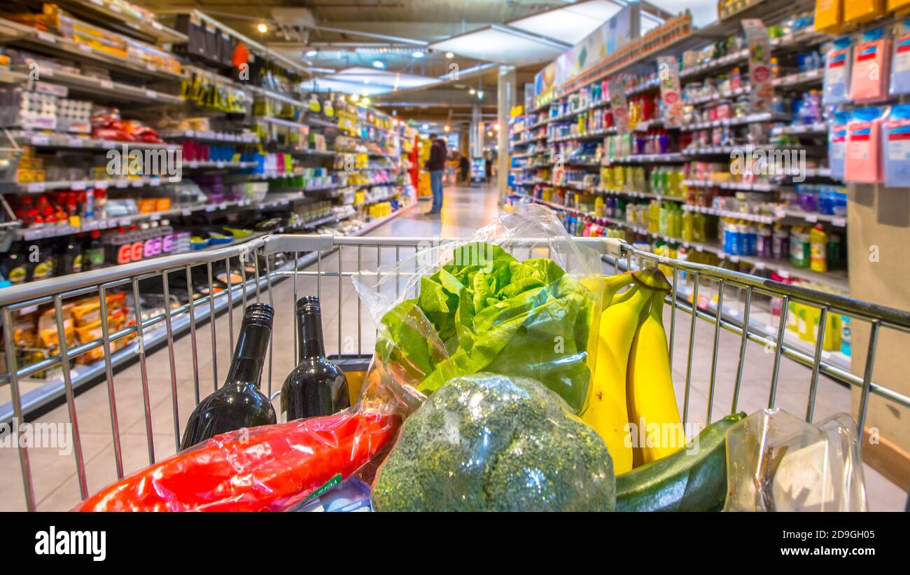 Grocery cart in supermarket filled with food products seen from the ...