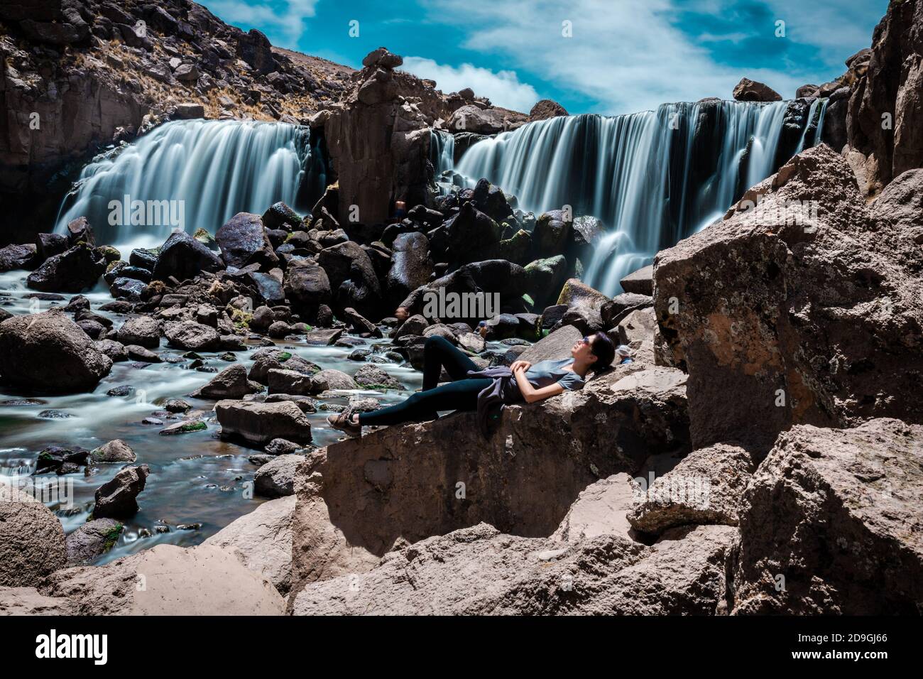 Female tourist lying on a rock at the Pillones Waterfall in Stone ...