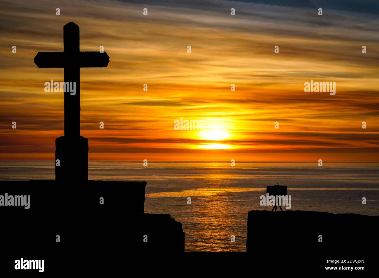sunset in orange and red tones with the backlight of a cross and a ...