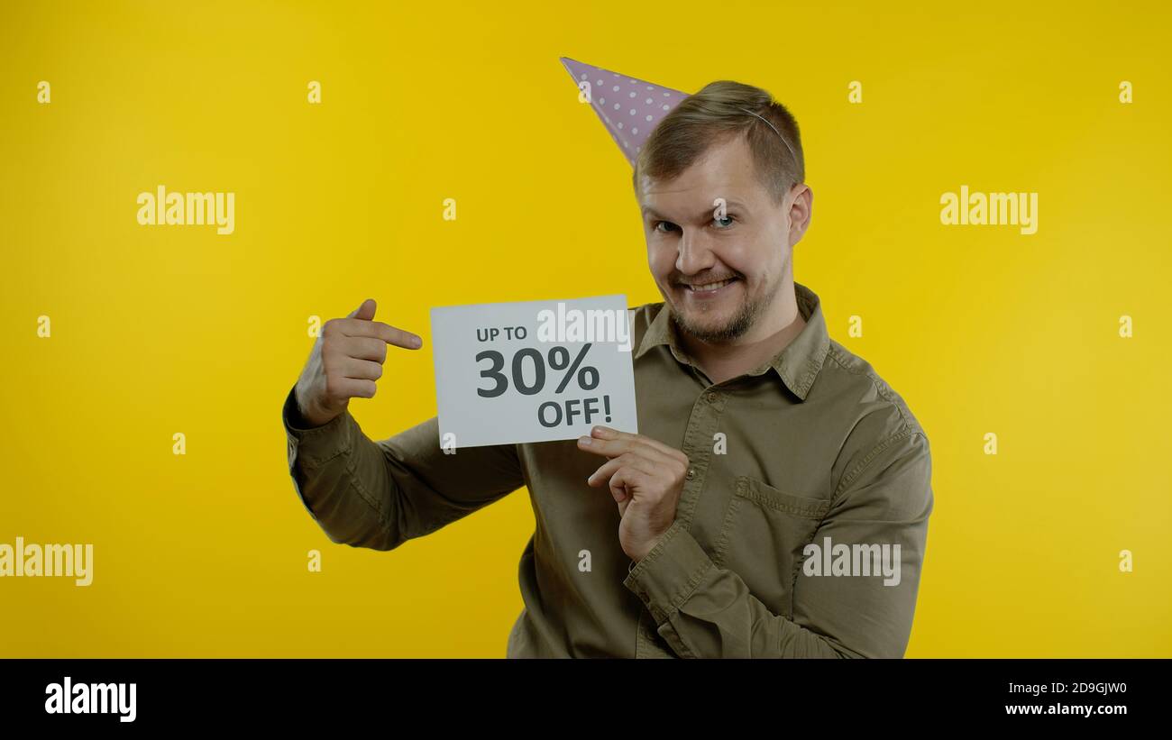 Great discounts. Happy joyful man in festive cap showing Up To 30 ...