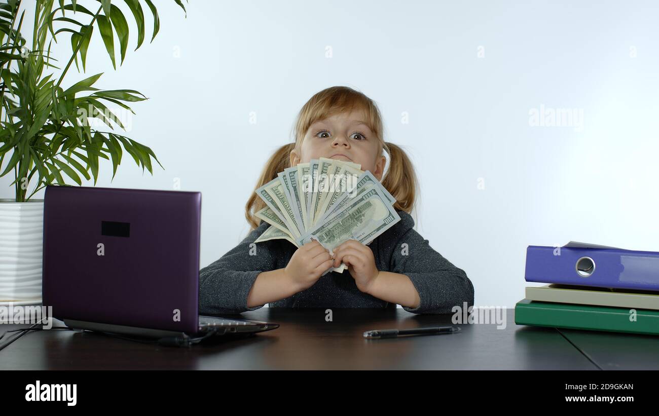 Child girl boss earns money. Little pretty boss kid hold much dollars ...