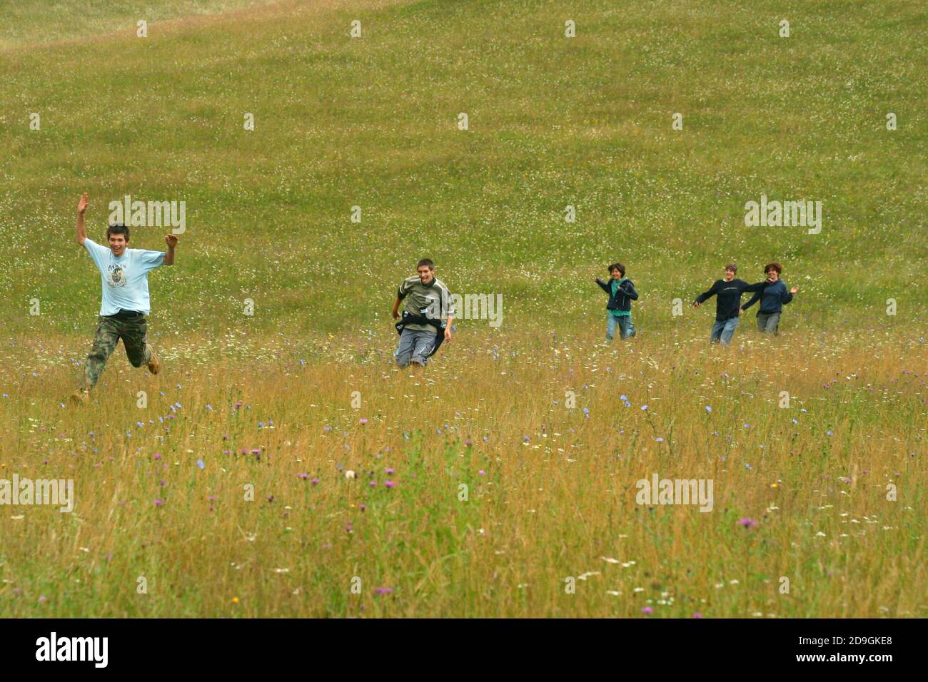 Young people running through a flower field Stock Photo - Alamy