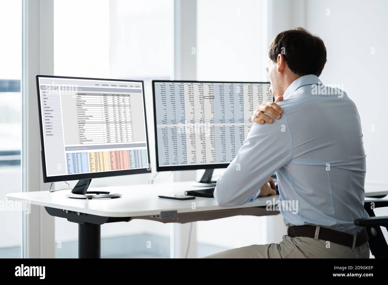 Young Businessman Having Shoulder Pain While Working At Computer Desk ...
