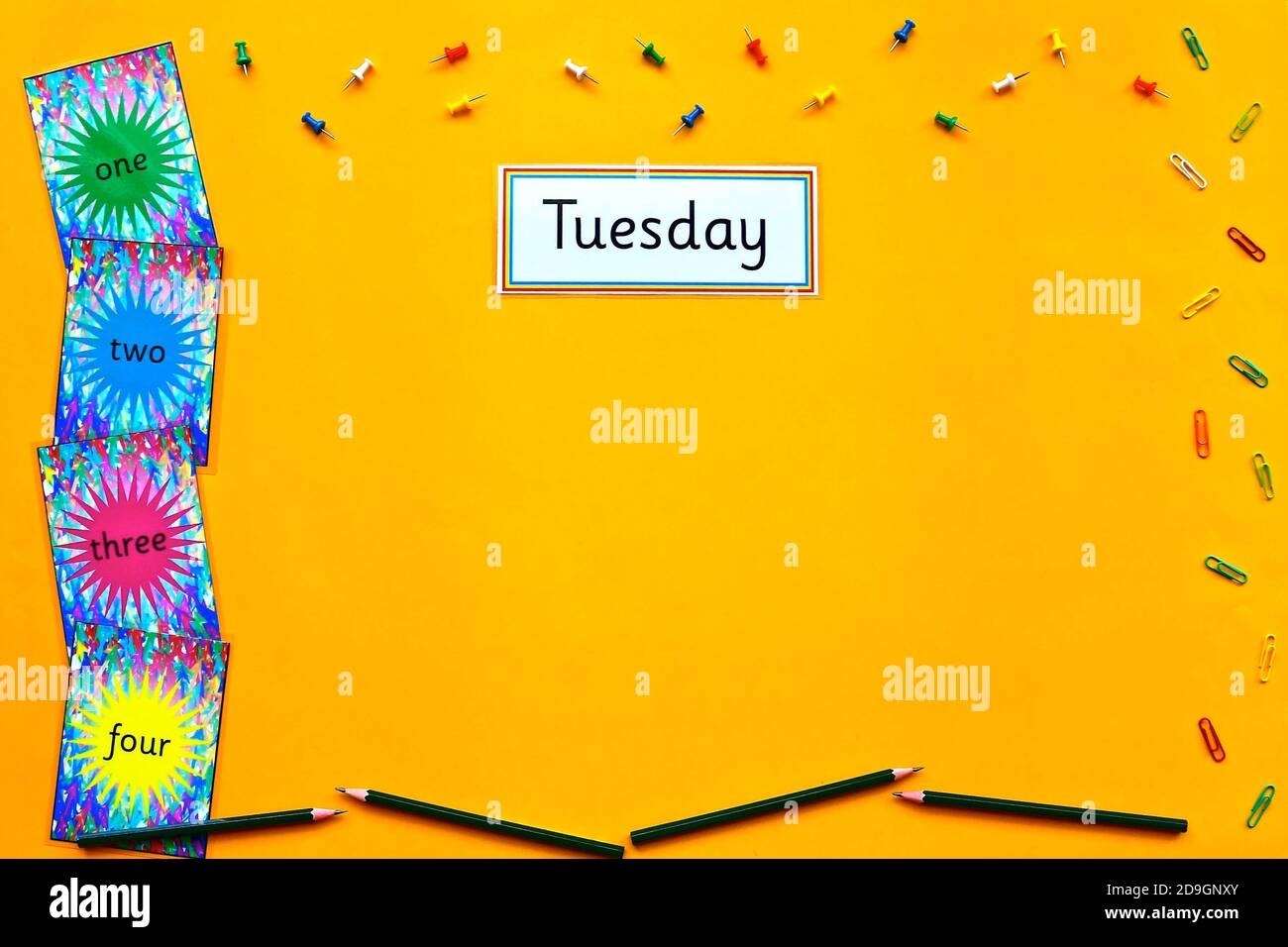 Education concept flatlay for Tuesday, on a yellow background, with ...