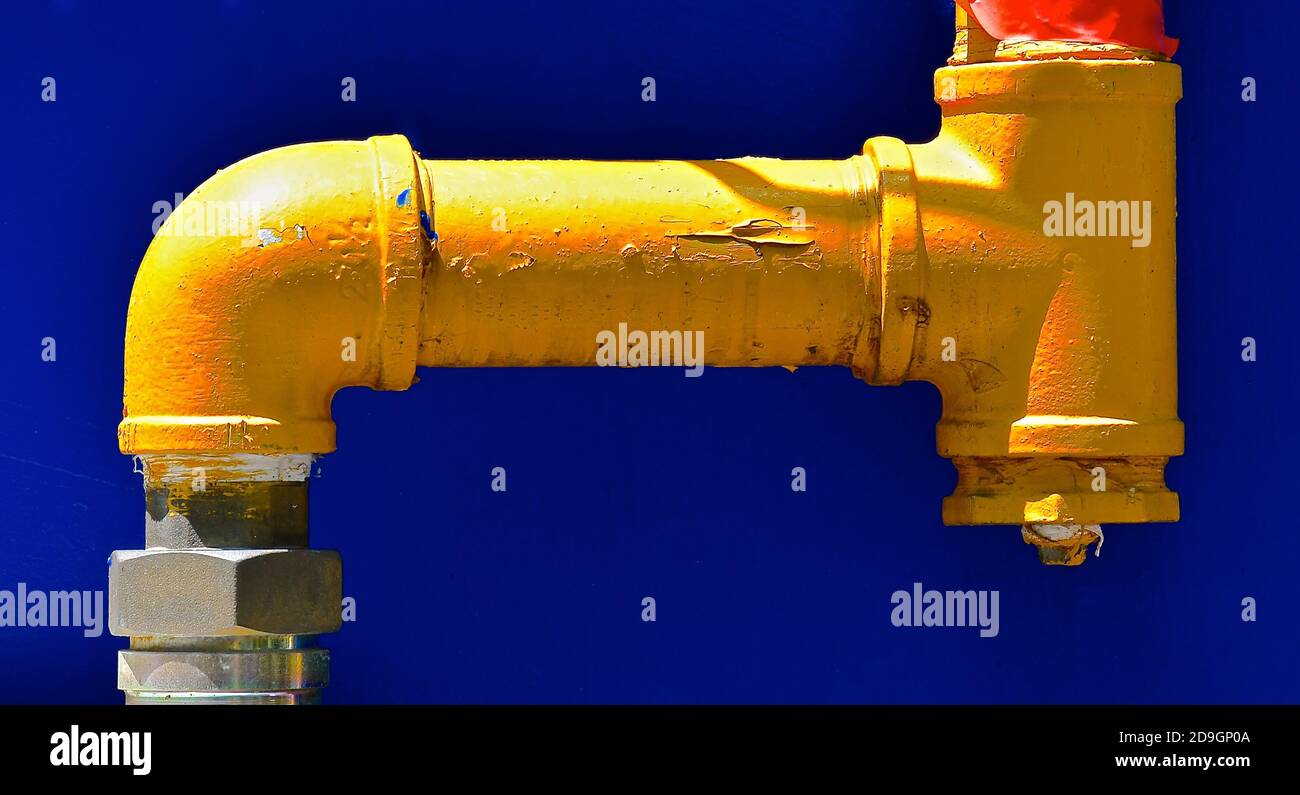 A heavy duty industrial yellow, metal water pipe isolated against a ...