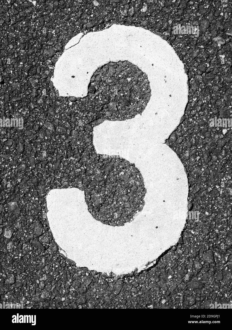 Vertical shot of a white number three on asphalt ground Stock Photo - Alamy