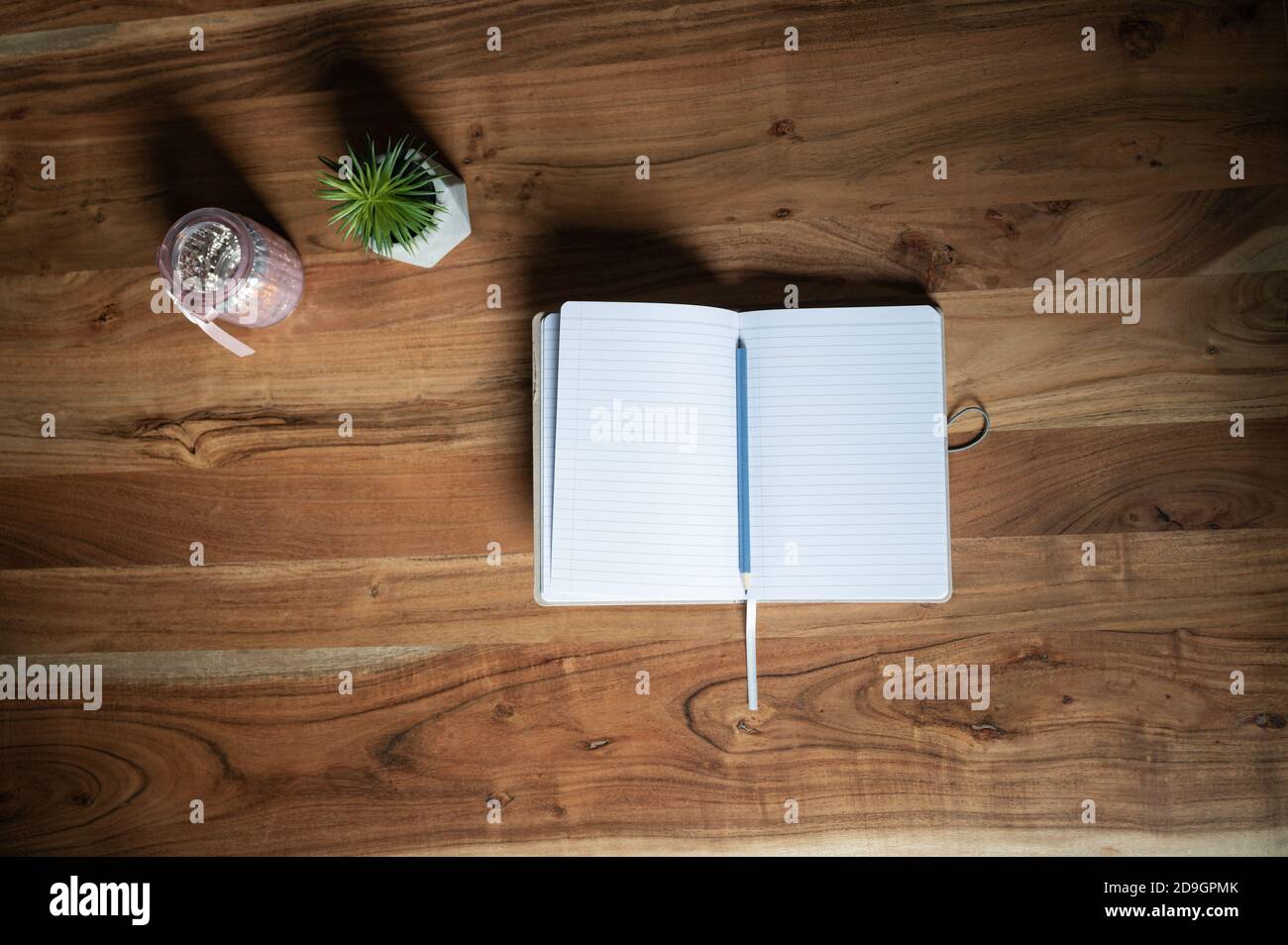 Top view of an open blank notebook with pencil on it lying on wooden ...