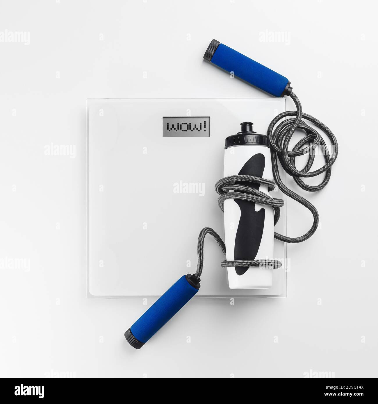 Scales with jumping rope and bottle of water on white background ...