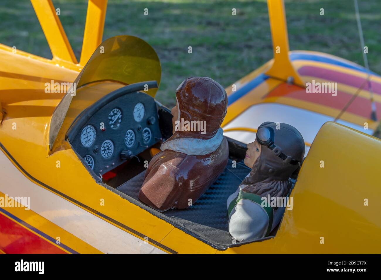 Yellow biplane with pilot figures in the cockpit Stock Photo - Alamy