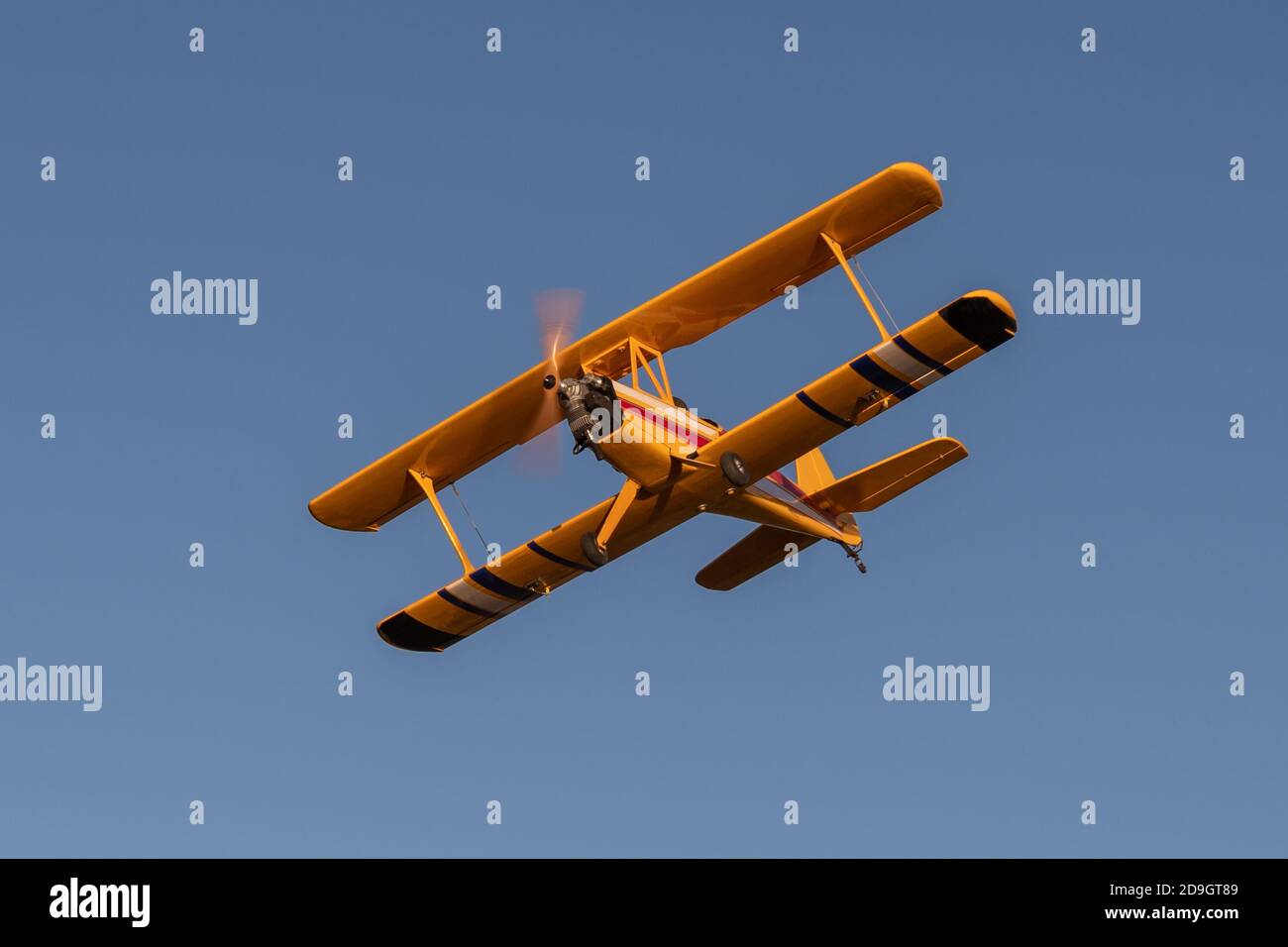 Yellow biplane with radio control flying in the blue sky Stock Photo ...