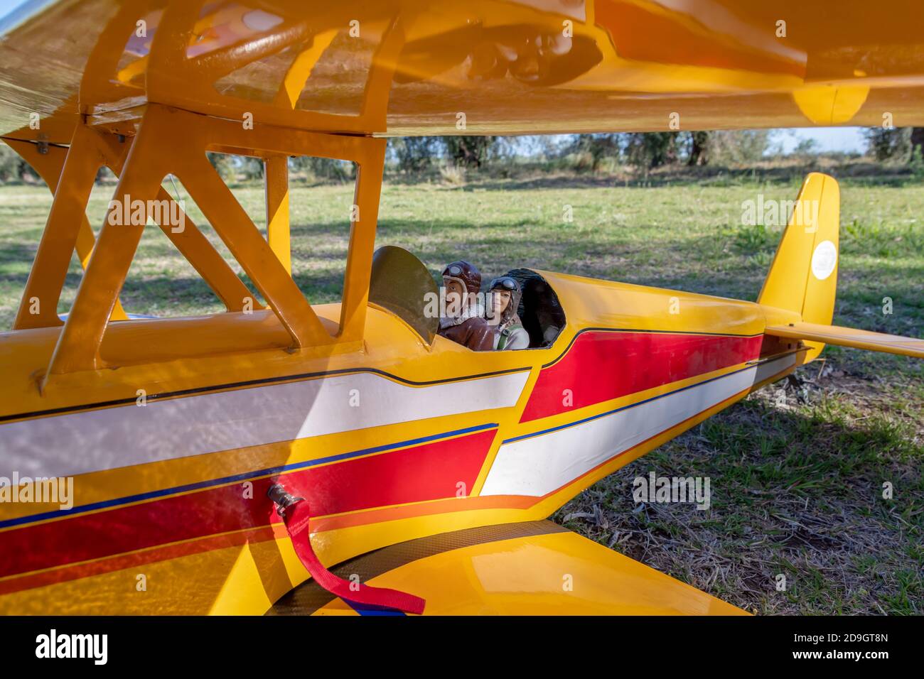 Yellow biplane with pilot figures in the cockpit Stock Photo - Alamy