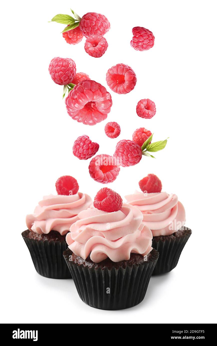 Delicious cupcakes and falling raspberry on white background Stock ...