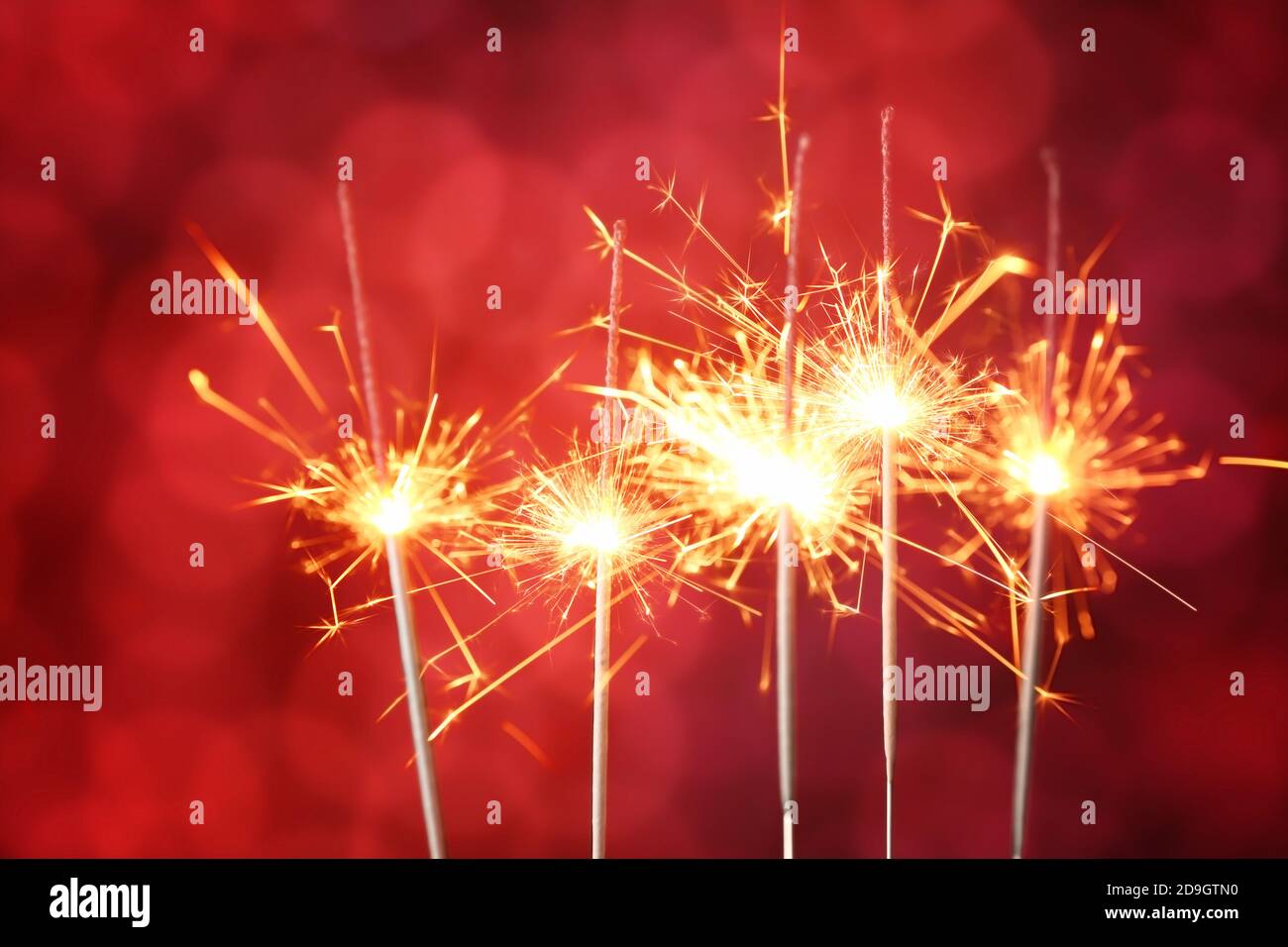 Beautiful Christmas sparklers on color background with blurred lights ...