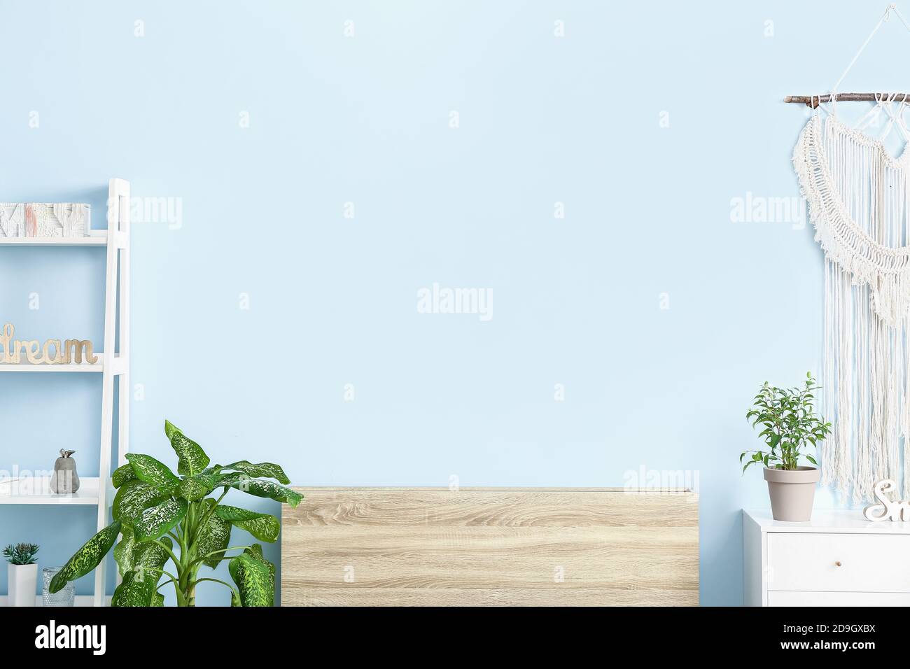 Stylish interior of room with wooden stand, chest of drawers and rack ...