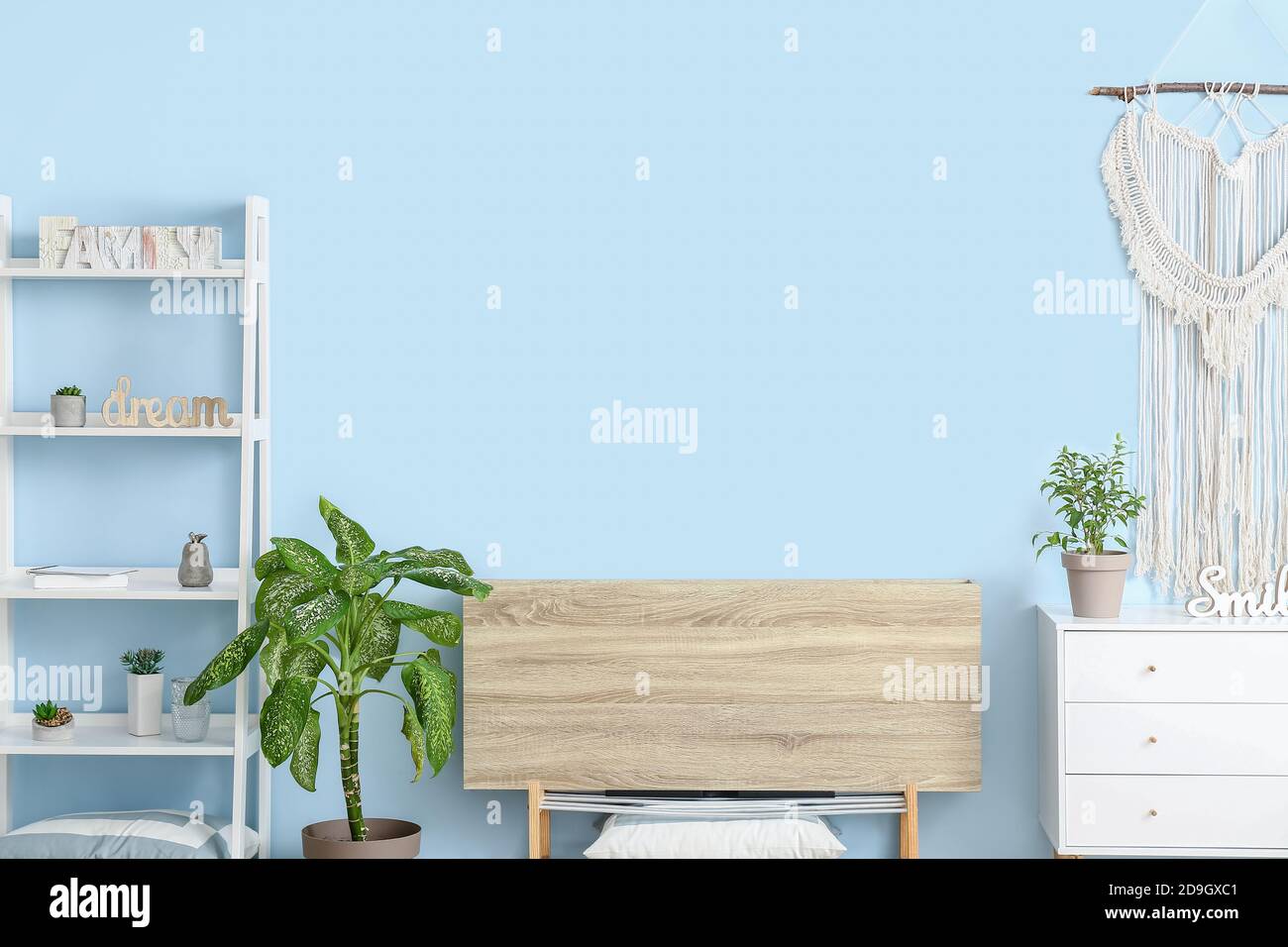 Stylish interior of room with wooden stand, chest of drawers and rack ...