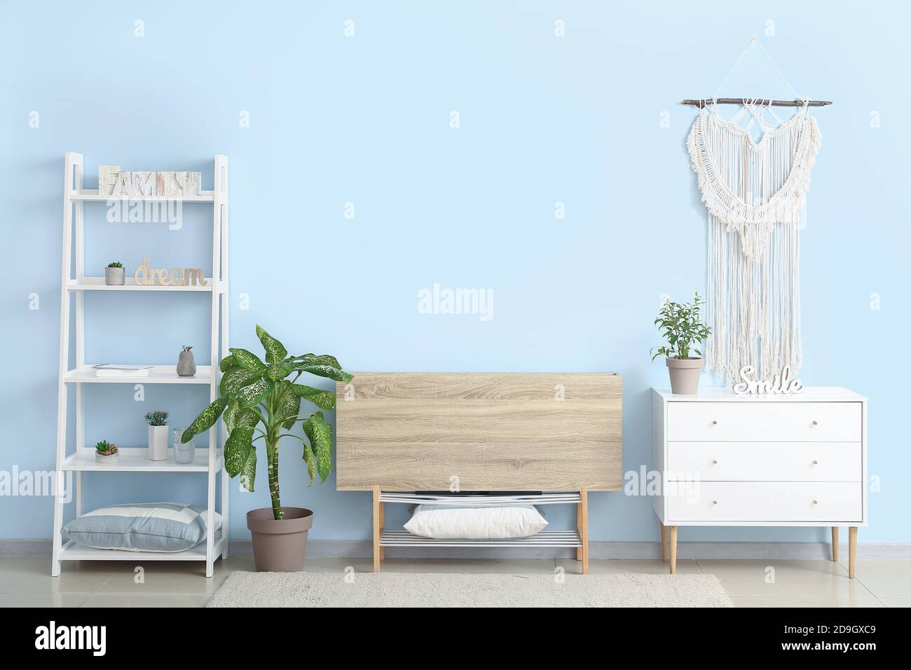 Stylish interior of room with wooden stand, chest of drawers and rack ...