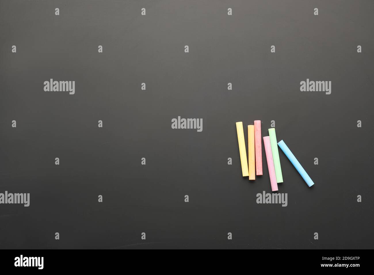 Pieces of colorful chalk on blackboard, top view Stock Photo - Alamy