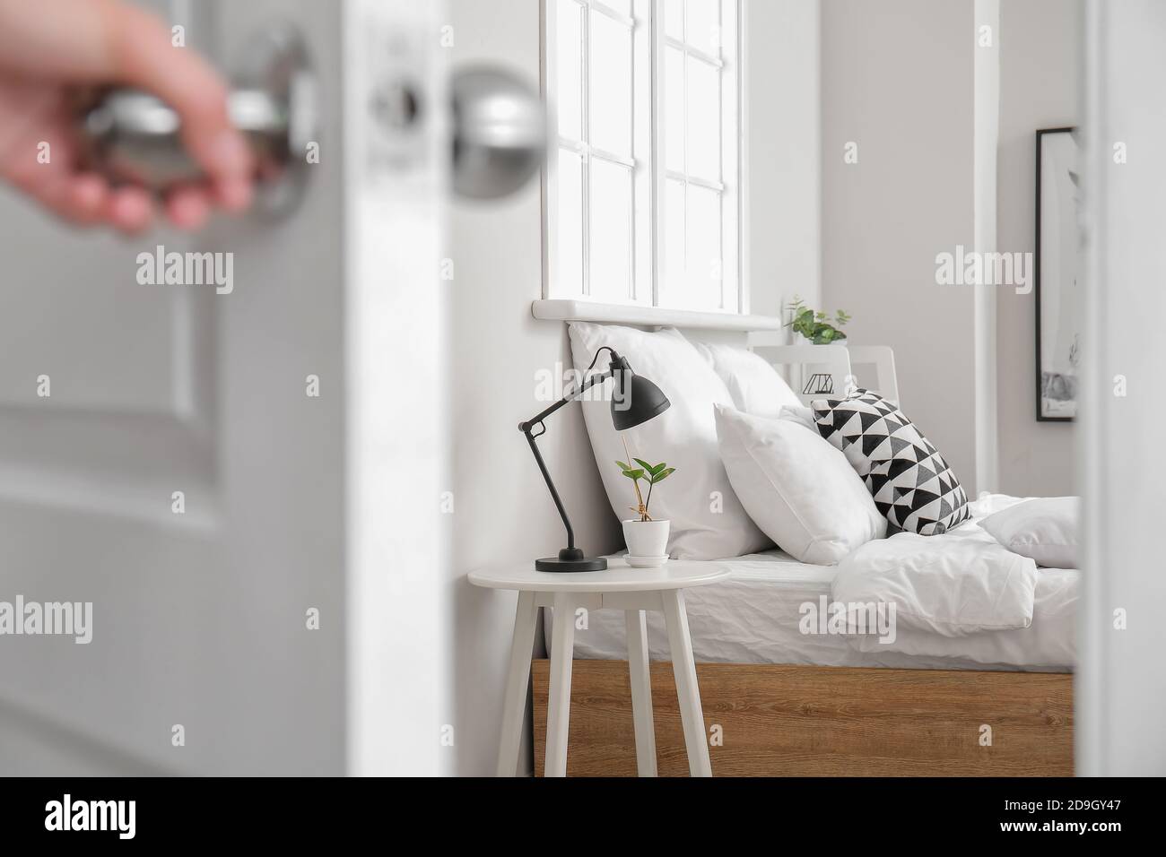 Woman opening door in modern bedroom Stock Photo - Alamy