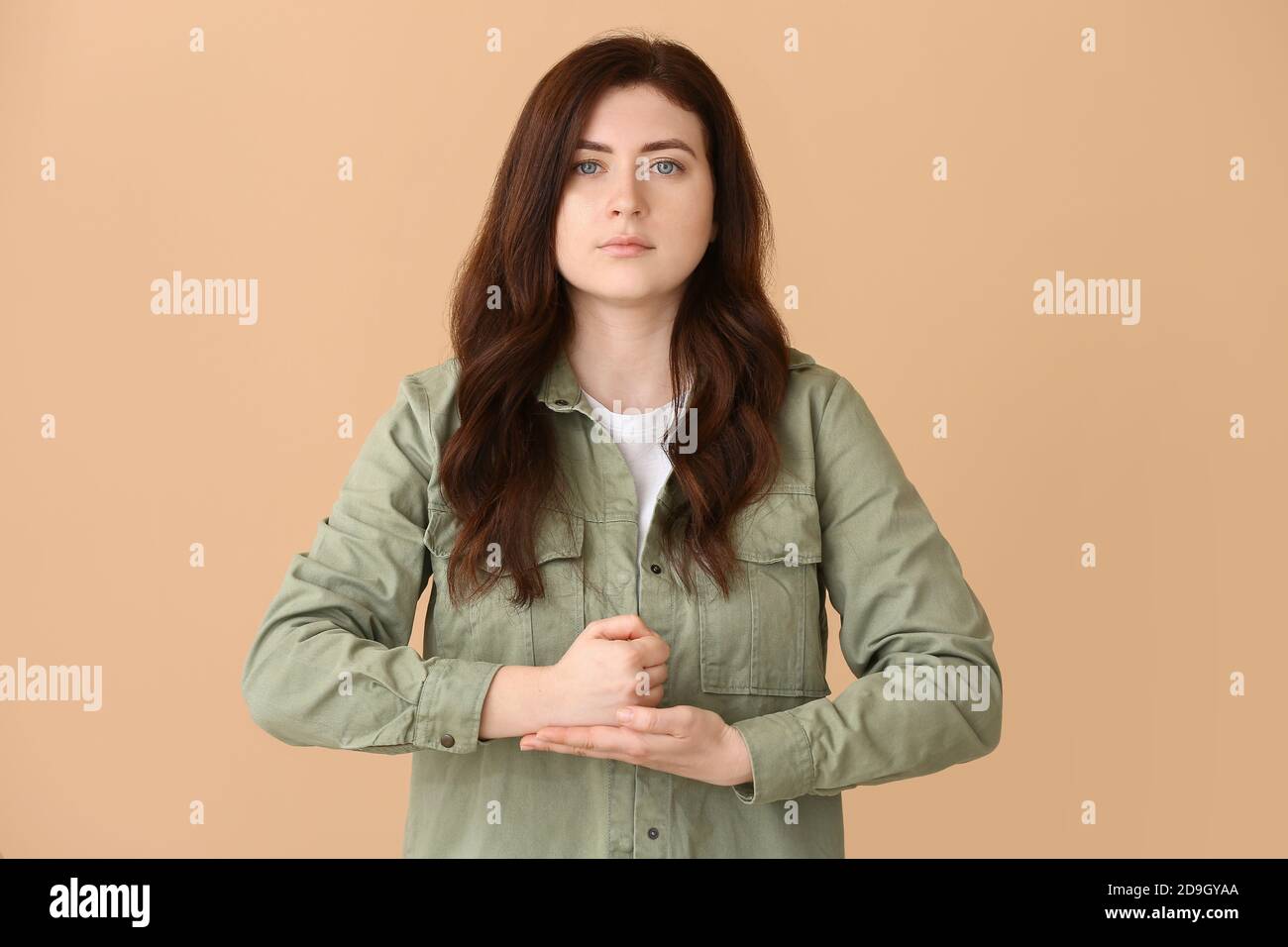 Young deaf mute woman using sign language on color background Stock ...
