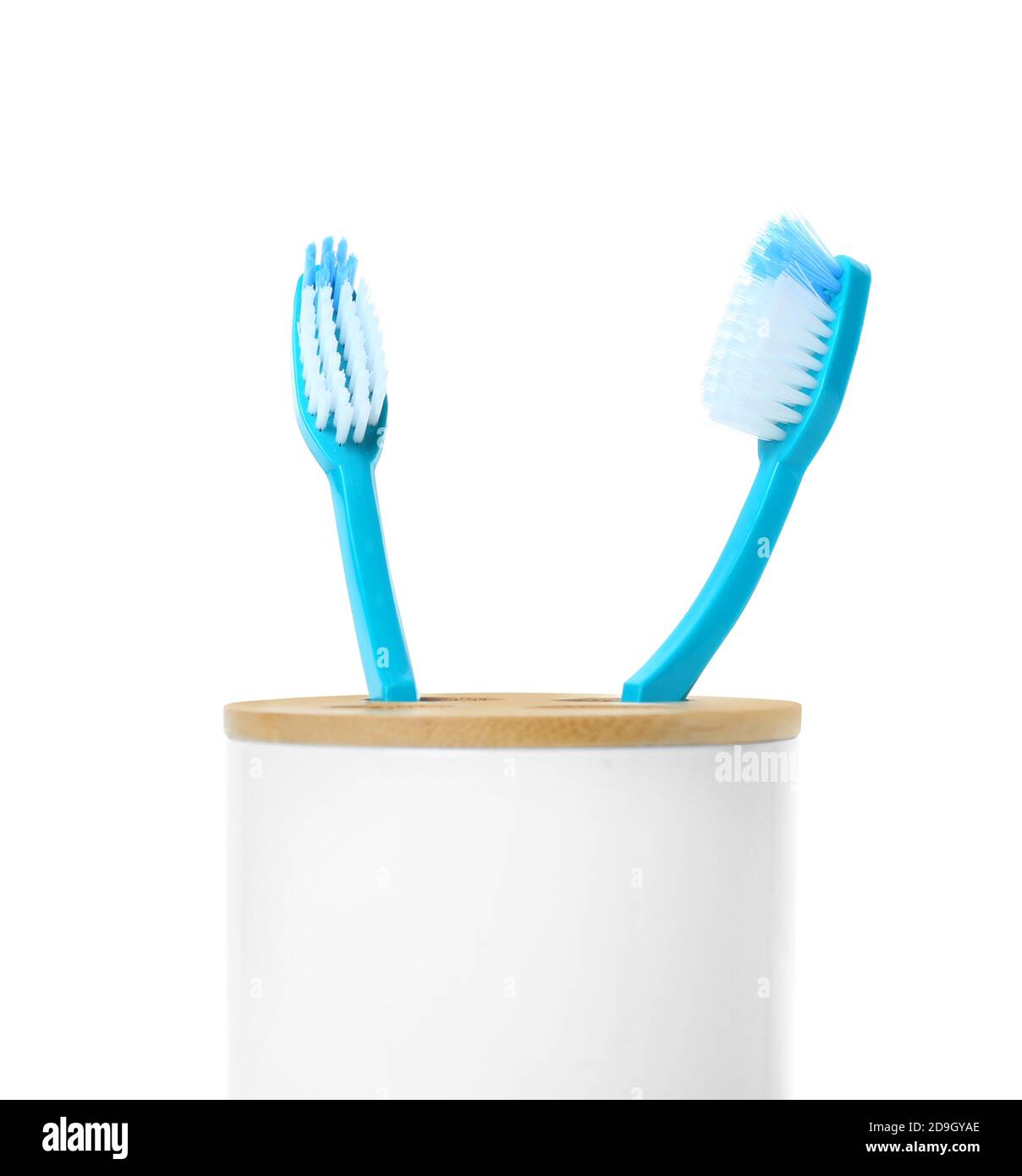 Cup with tooth brushes on white background Stock Photo - Alamy