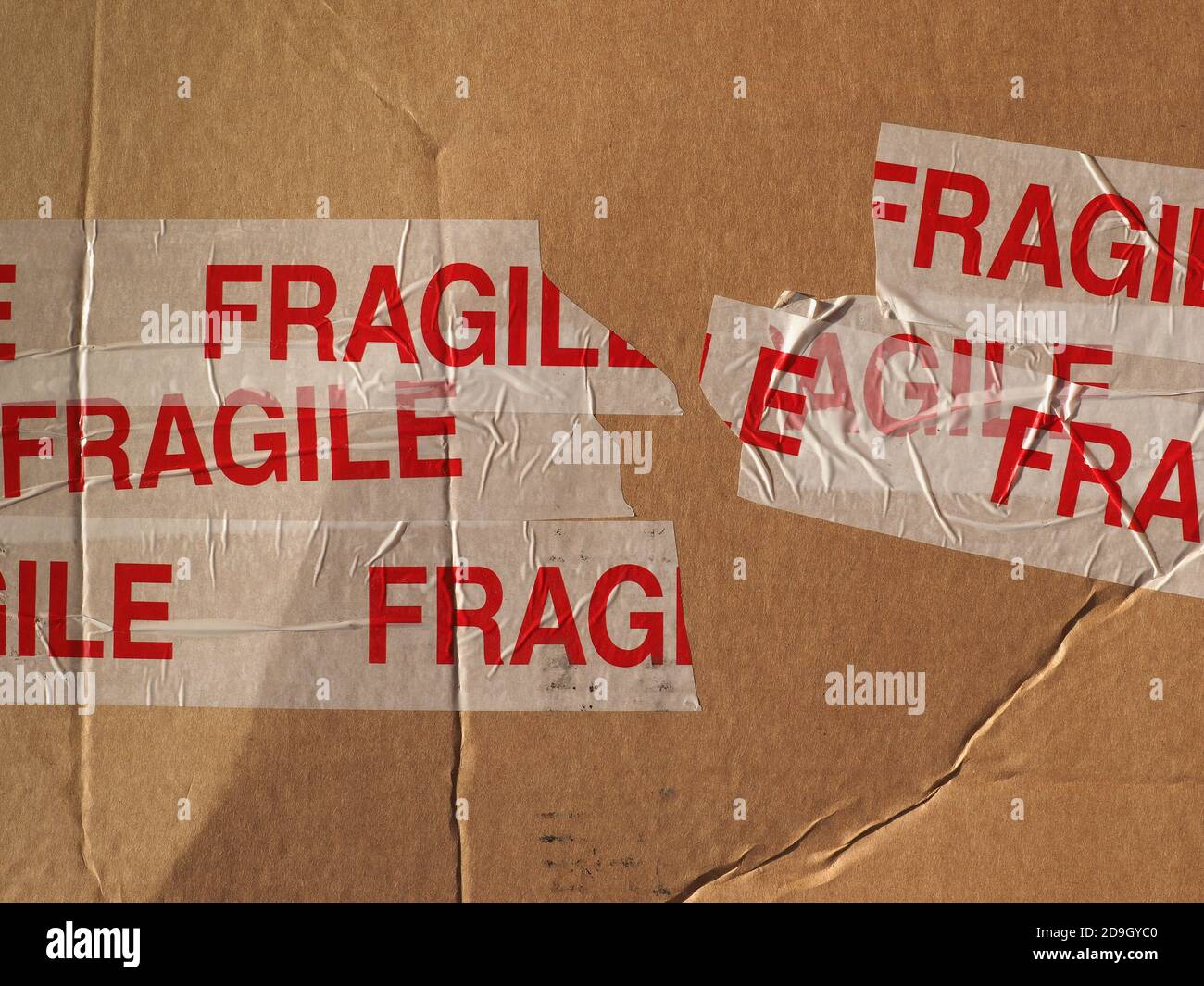 Fragile warning tape on corrugated cardboard box Stock Photo - Alamy