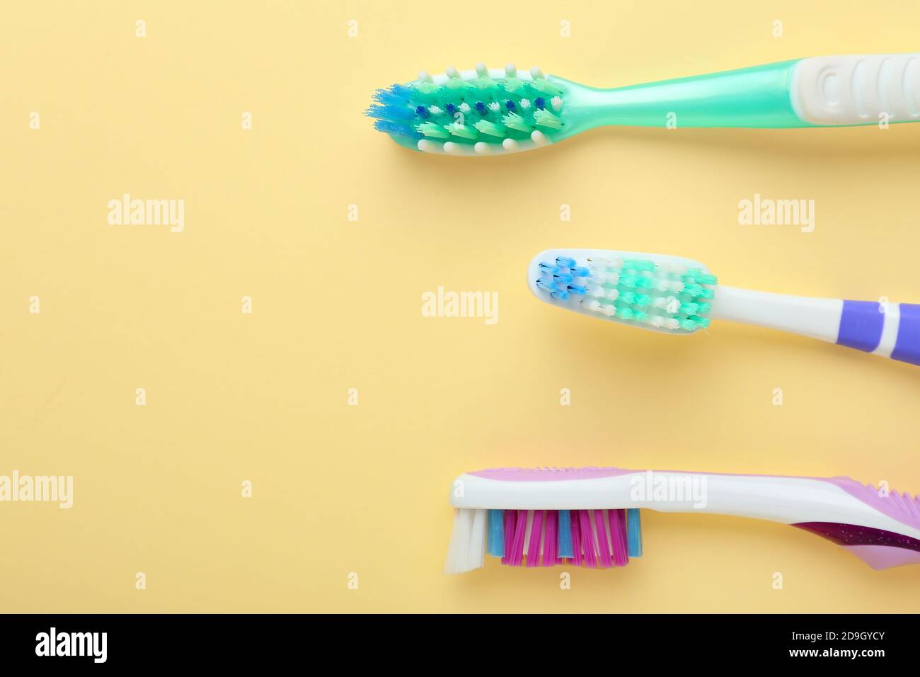 Tooth brushes on color background Stock Photo - Alamy