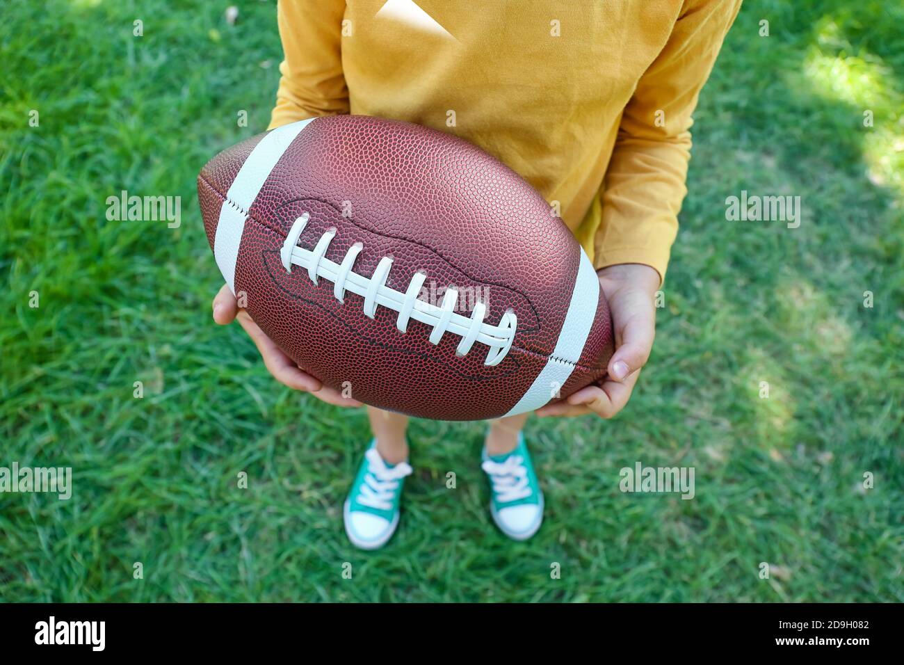 Little boy playing American football outdoors Stock Photo - Alamy