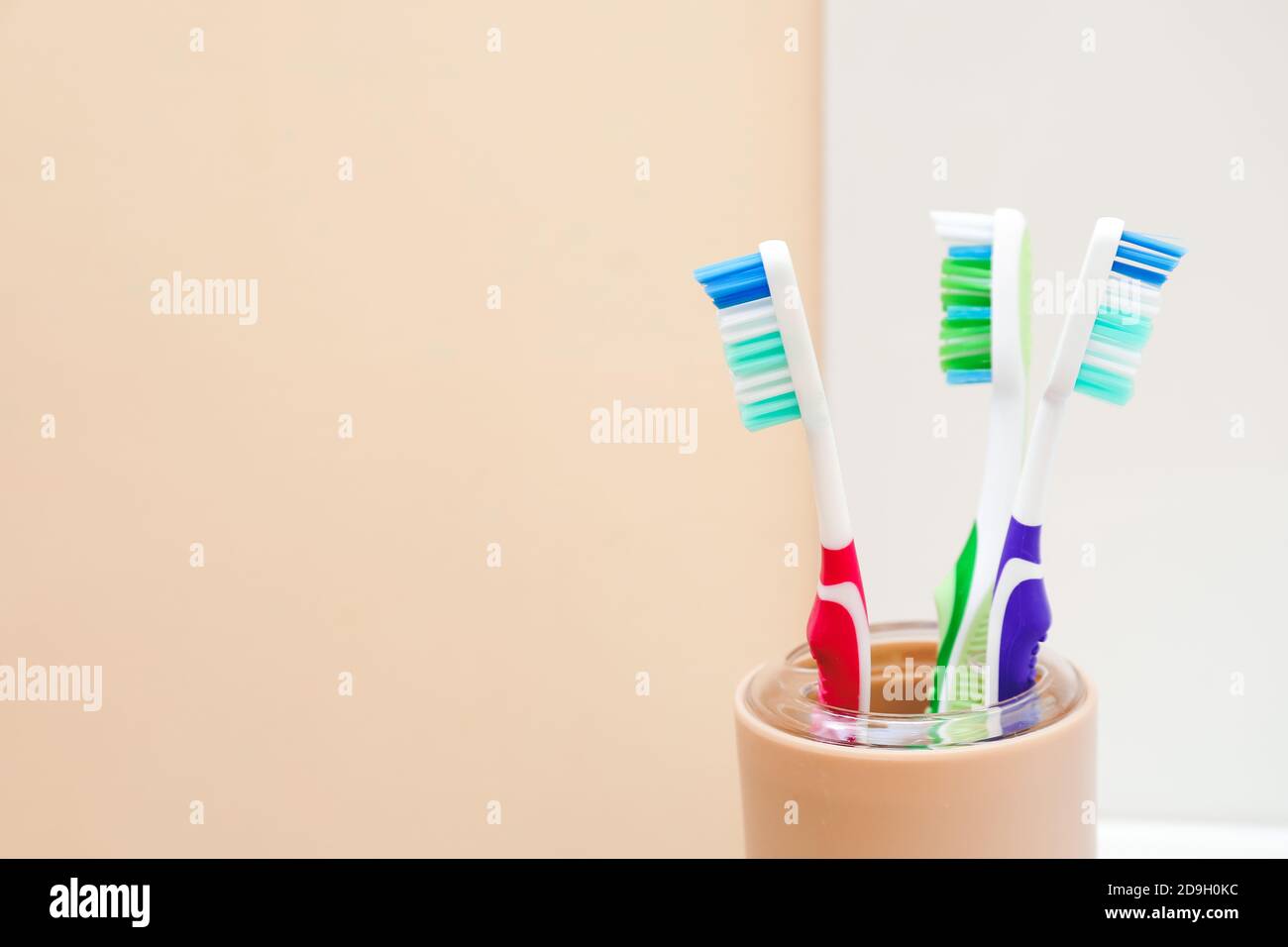 Cup with tooth brushes in bathroom Stock Photo - Alamy