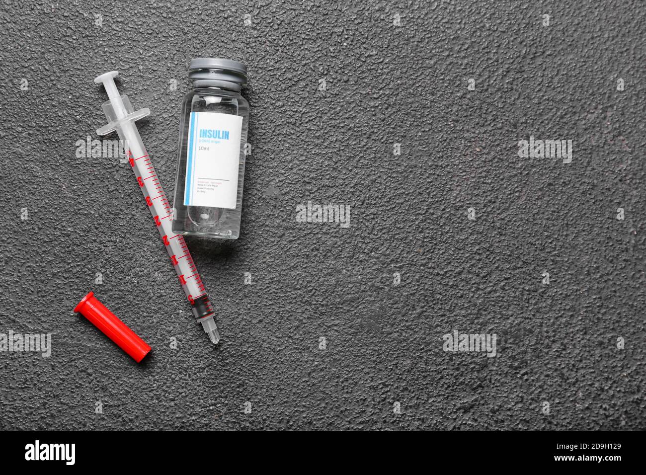 Bottle of insulin with syringe on dark background. Diabetes concept ...